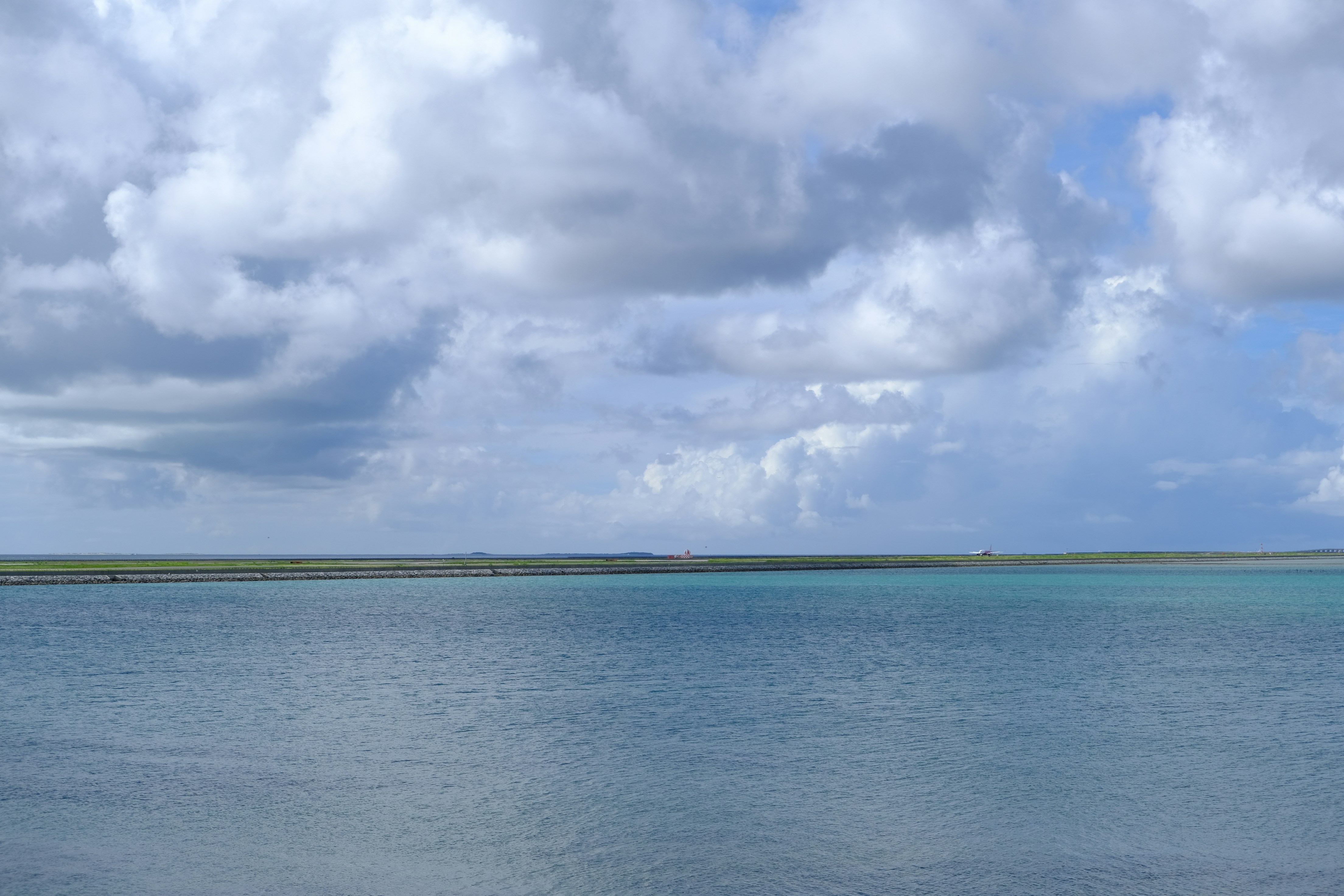 Calm blue ocean under a cloudy sky.