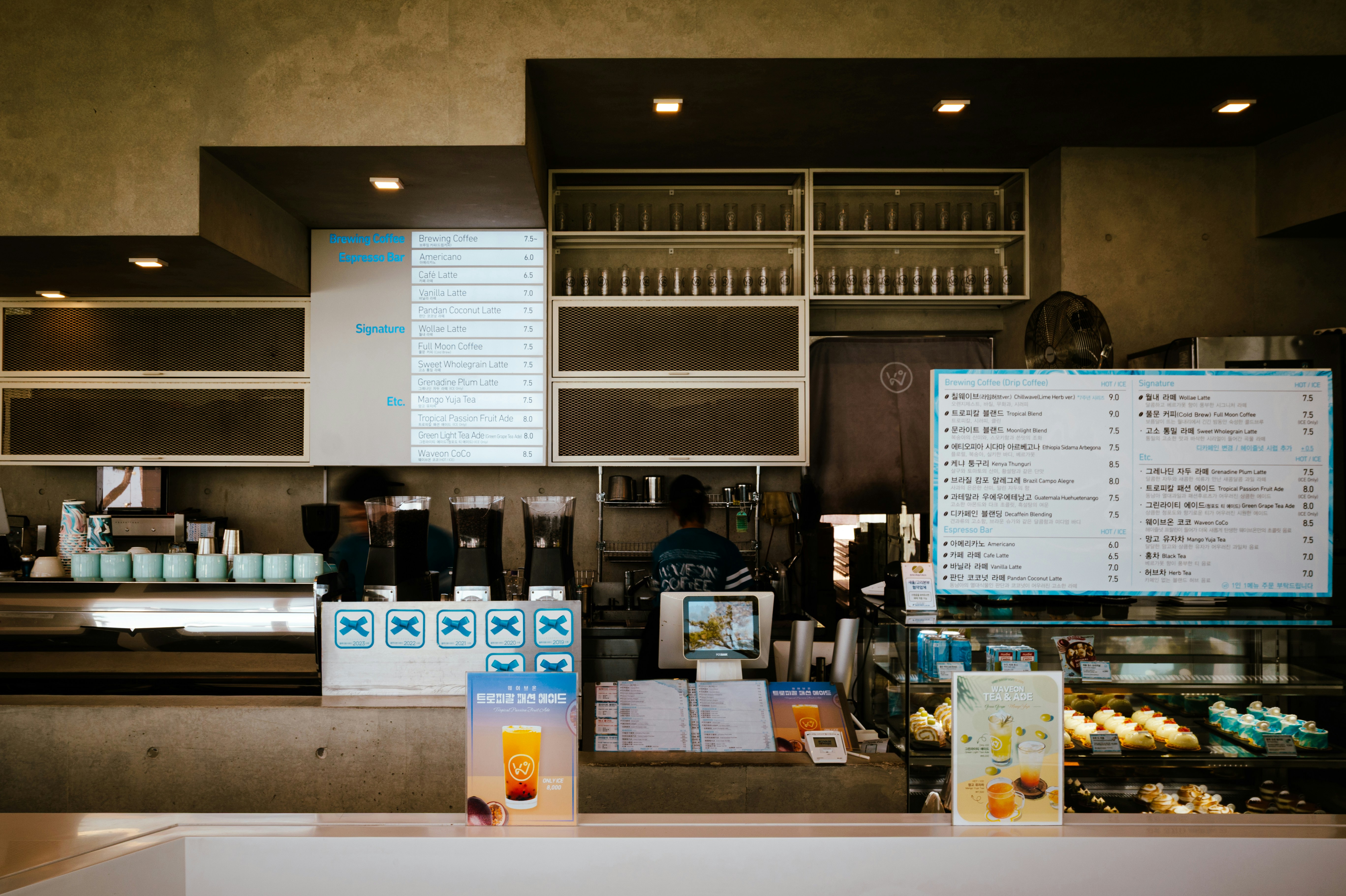Barista working behind a modern coffee shop counter.