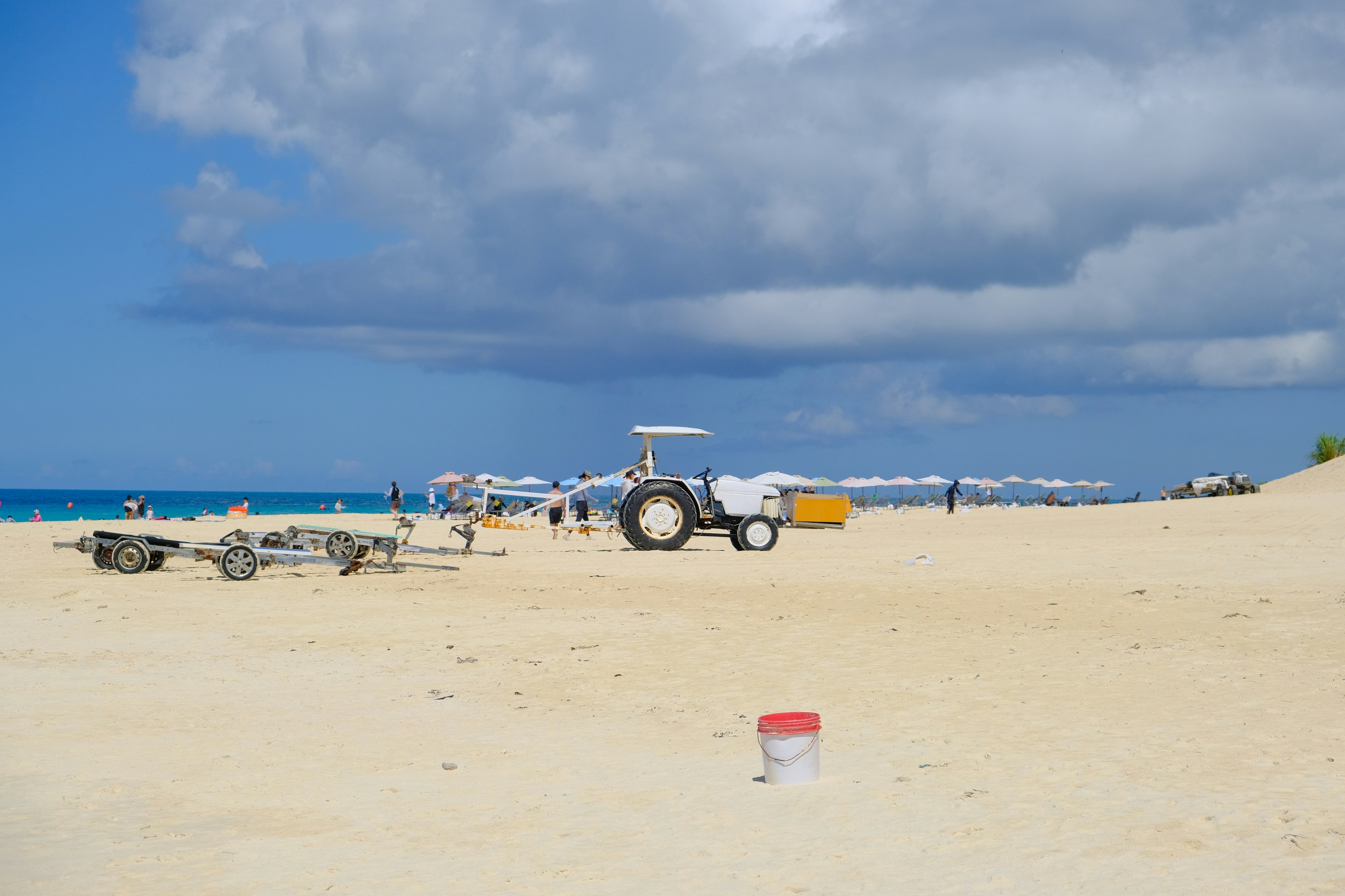 Beached Machinery: White Tractor Anchors a Quiet Seaside Day