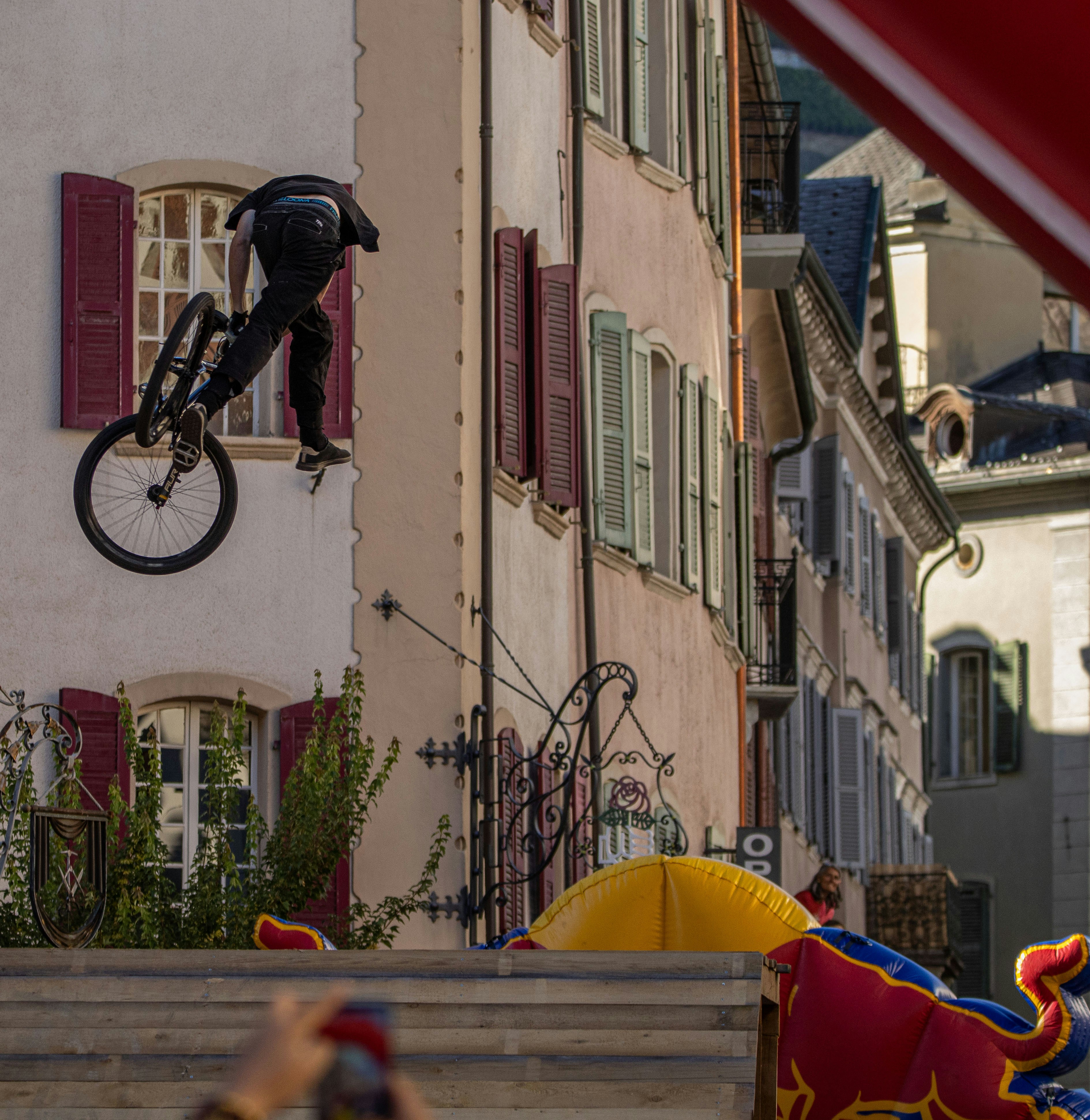 Air Time on the Facade: BMX Rider Skims the Sunlit European Street