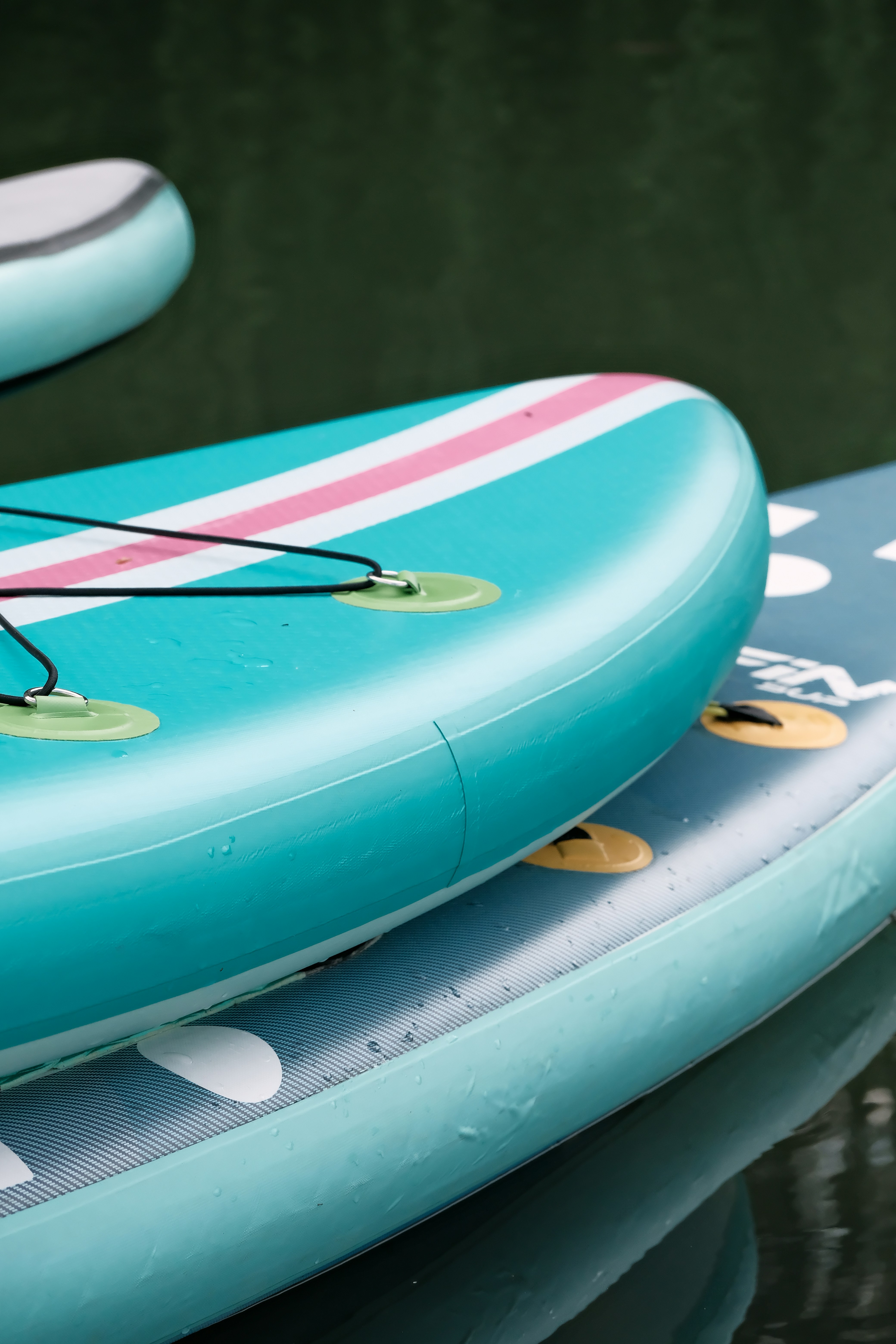 Teal SUP Duet: Striped Decks Resting on Calm Water