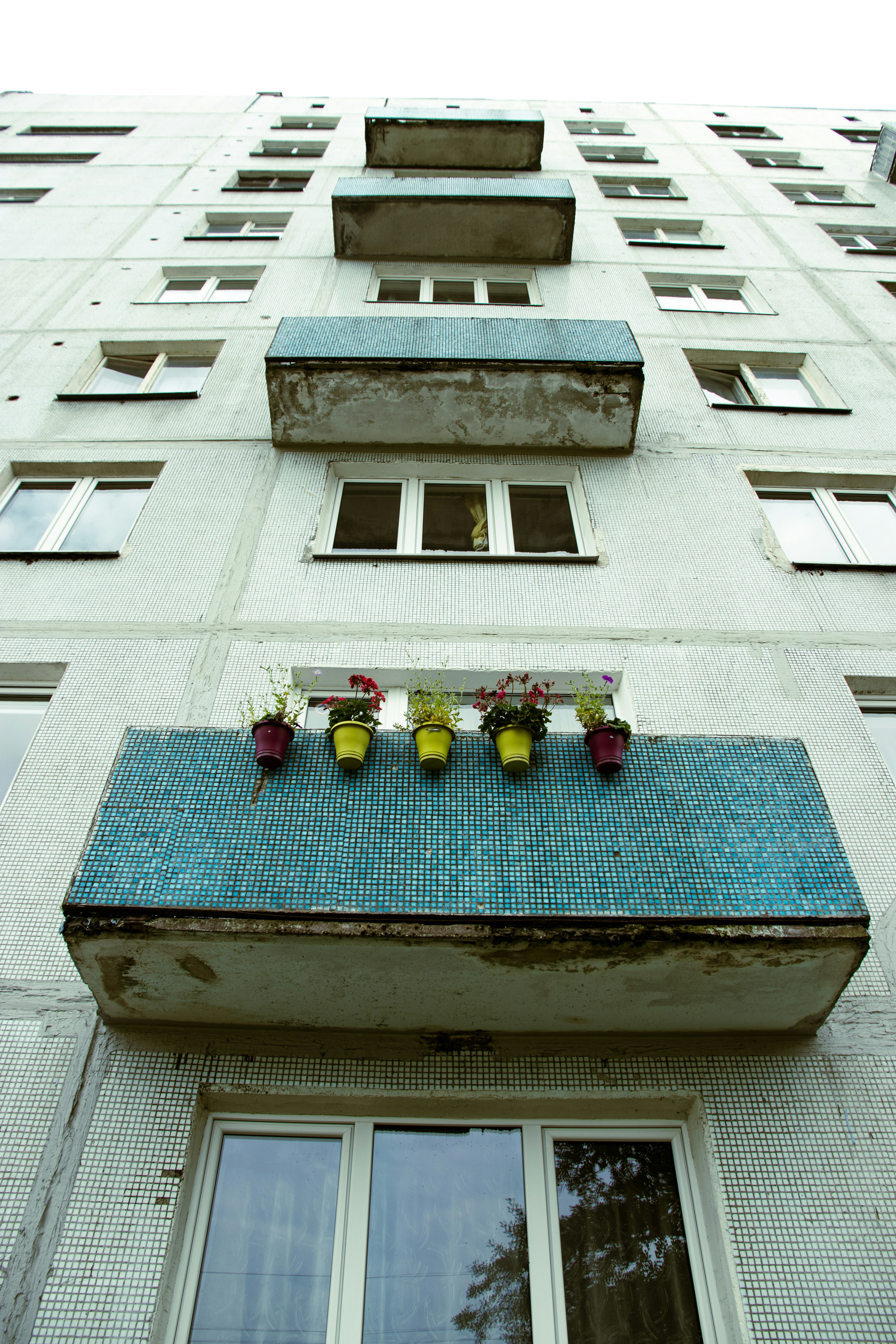 Balcony with potted flowers on a concrete building.