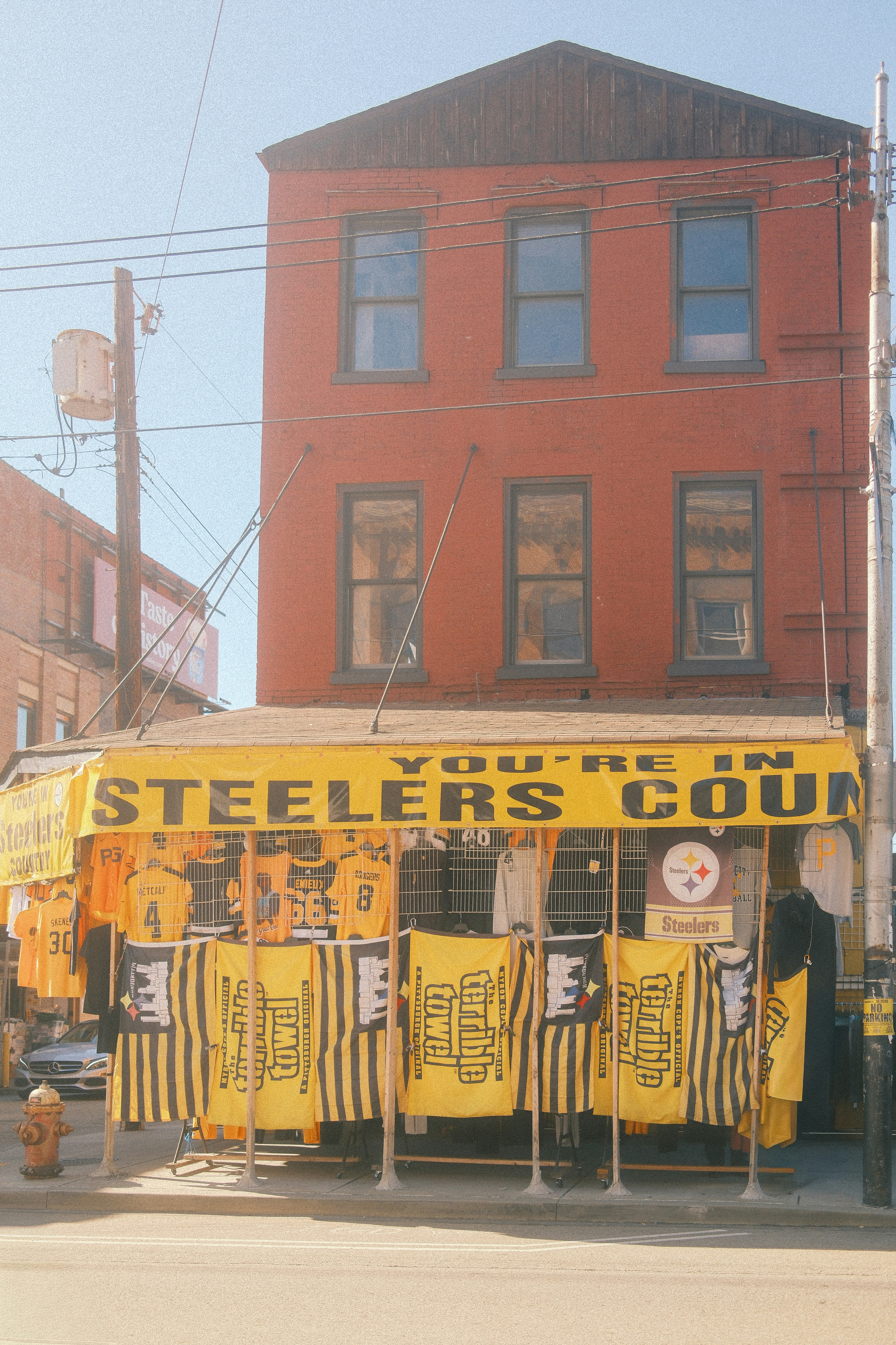 Yellow vendor canopy and brick building storefront under power lines
