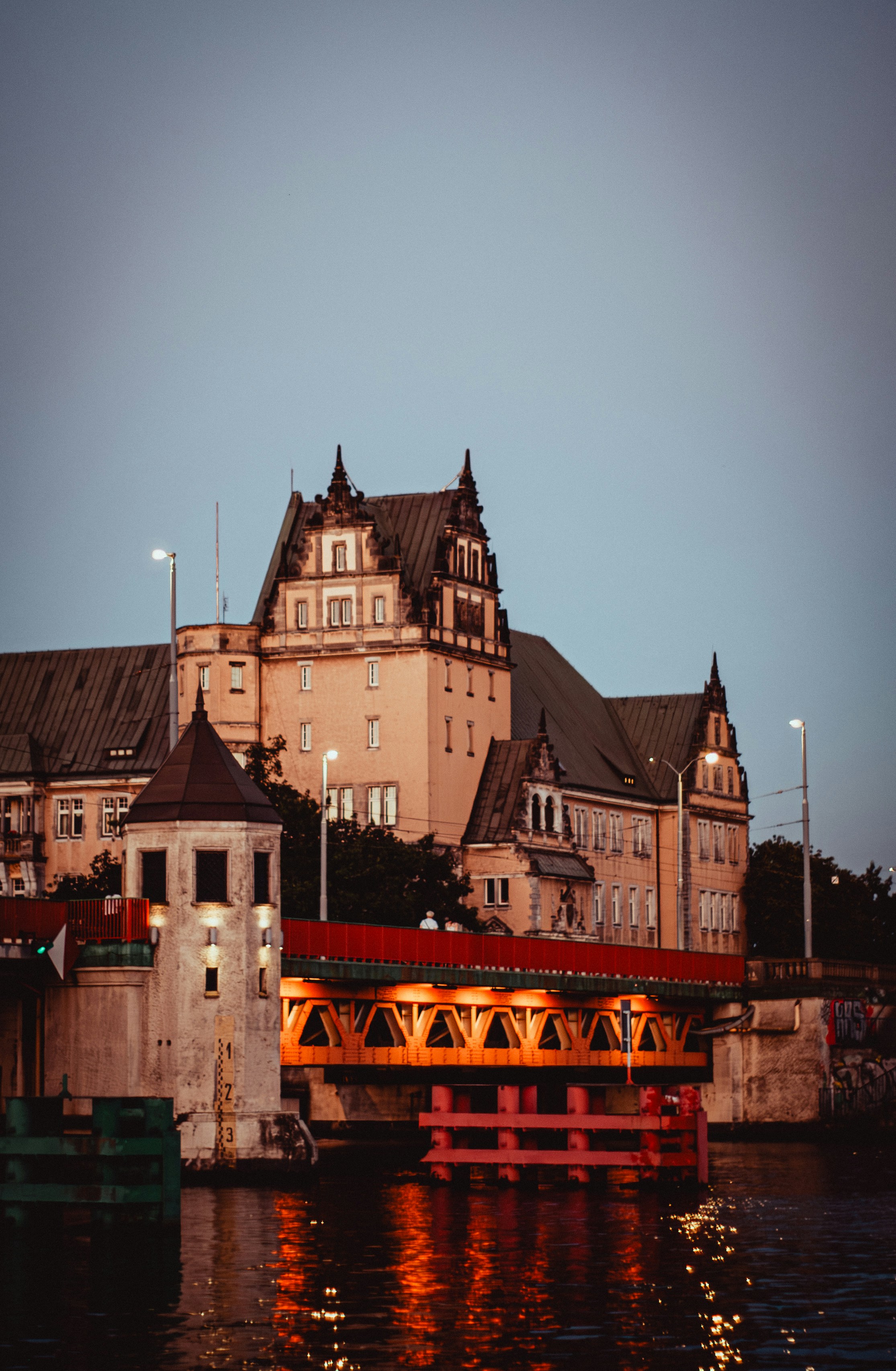 Historic building with bridge over water at dusk