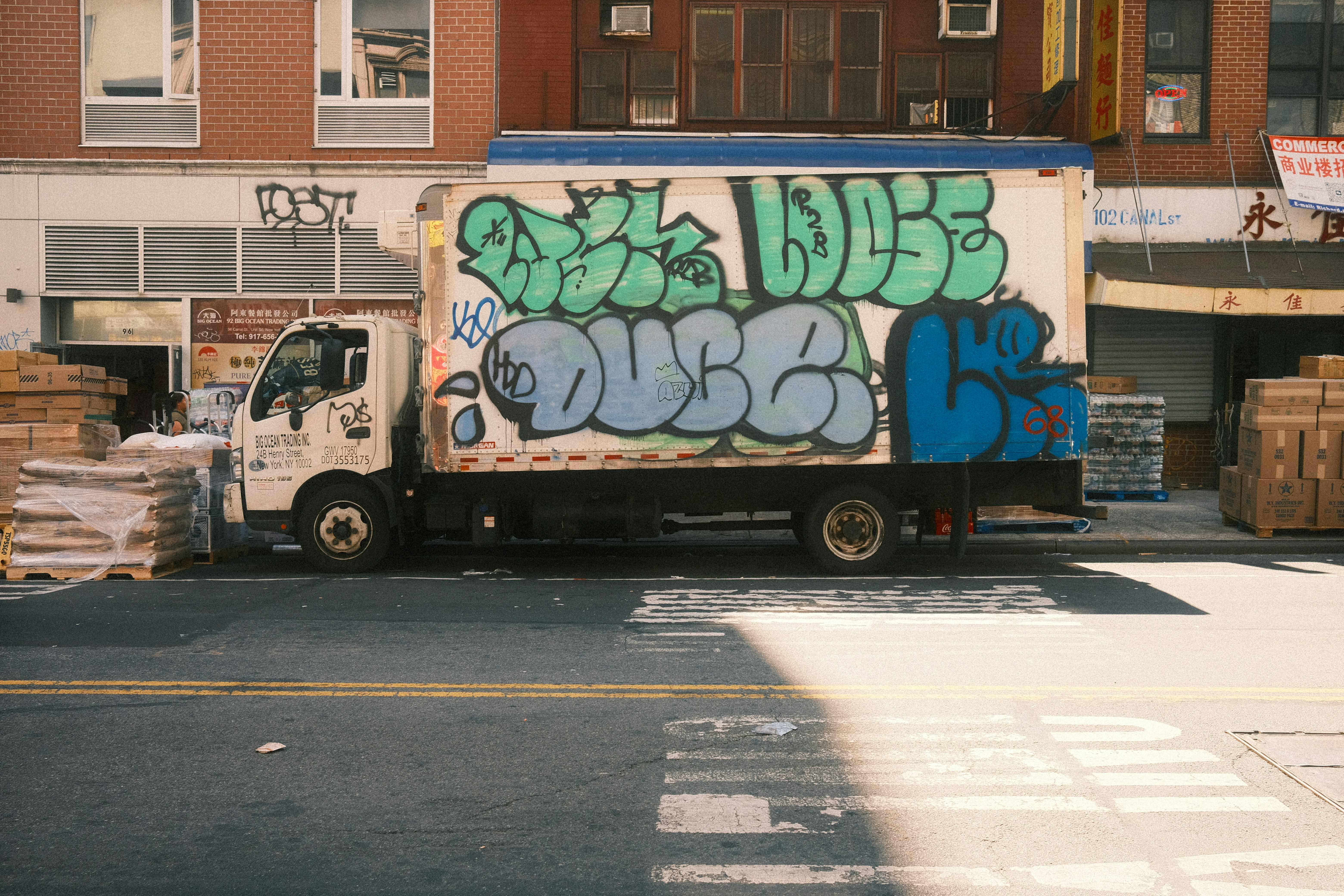 White truck covered in graffiti parked on street.