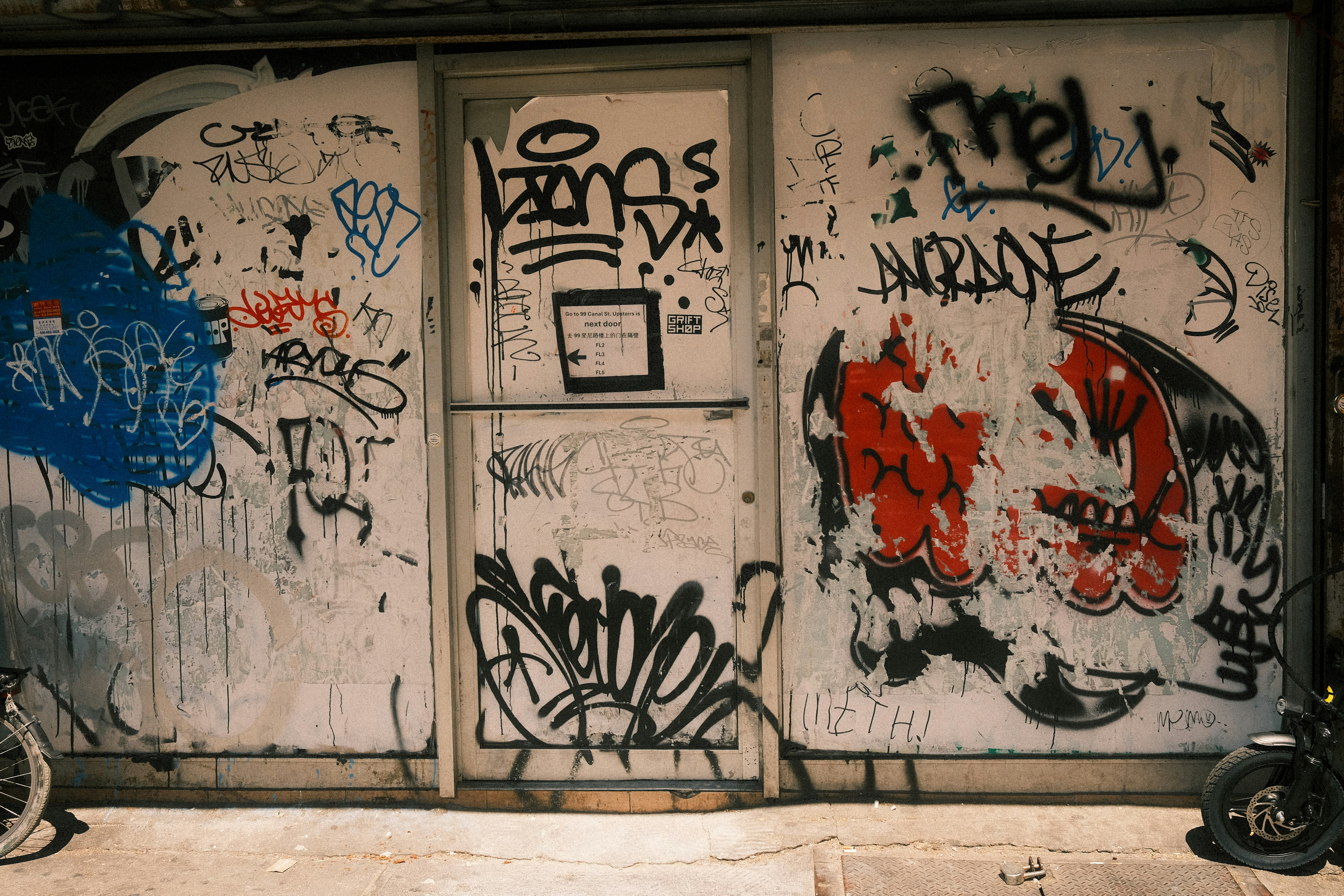 Graffiti-covered storefront door with urban decay.
