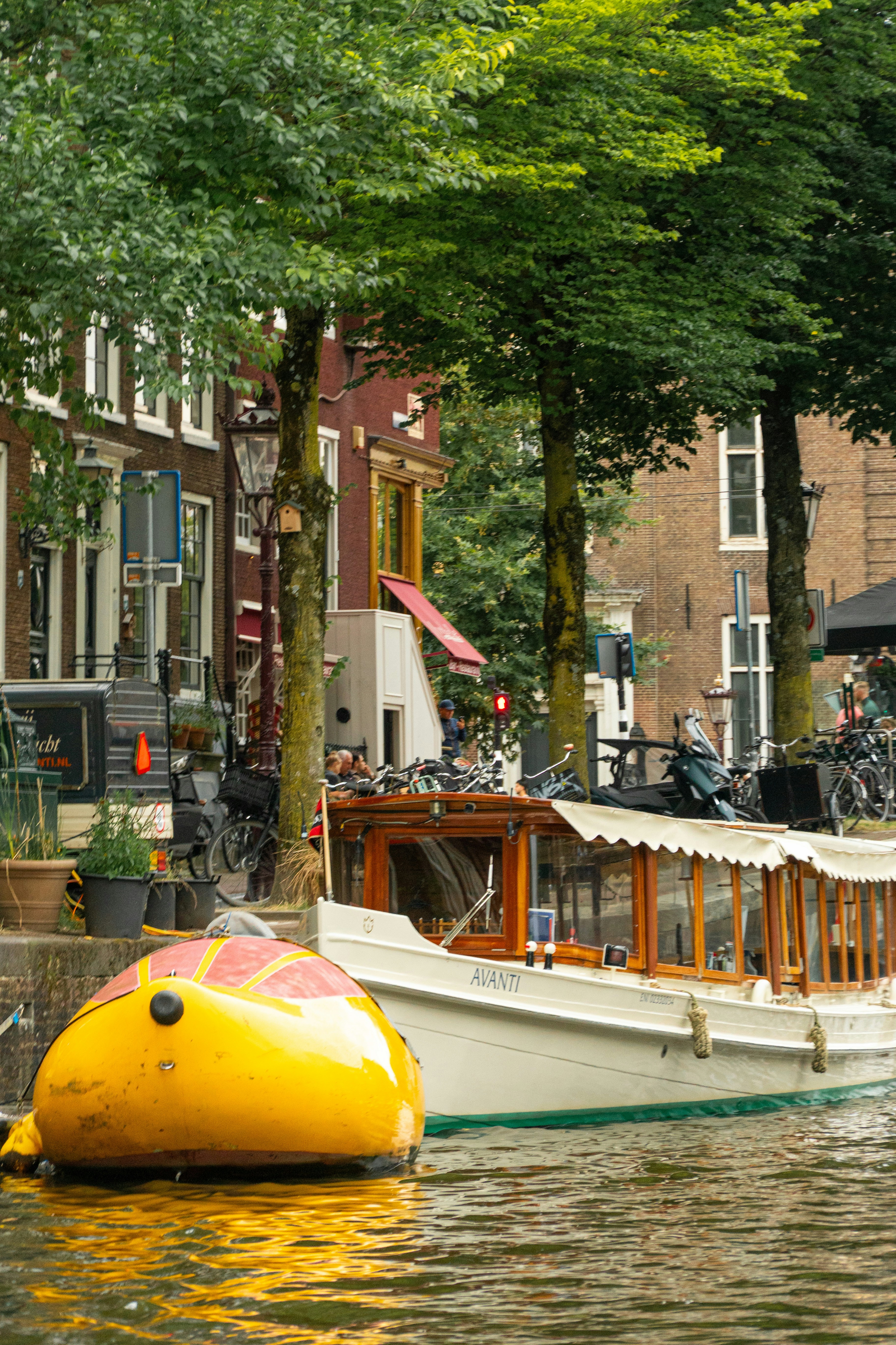 A boat on a canal next to a yellow buoy.