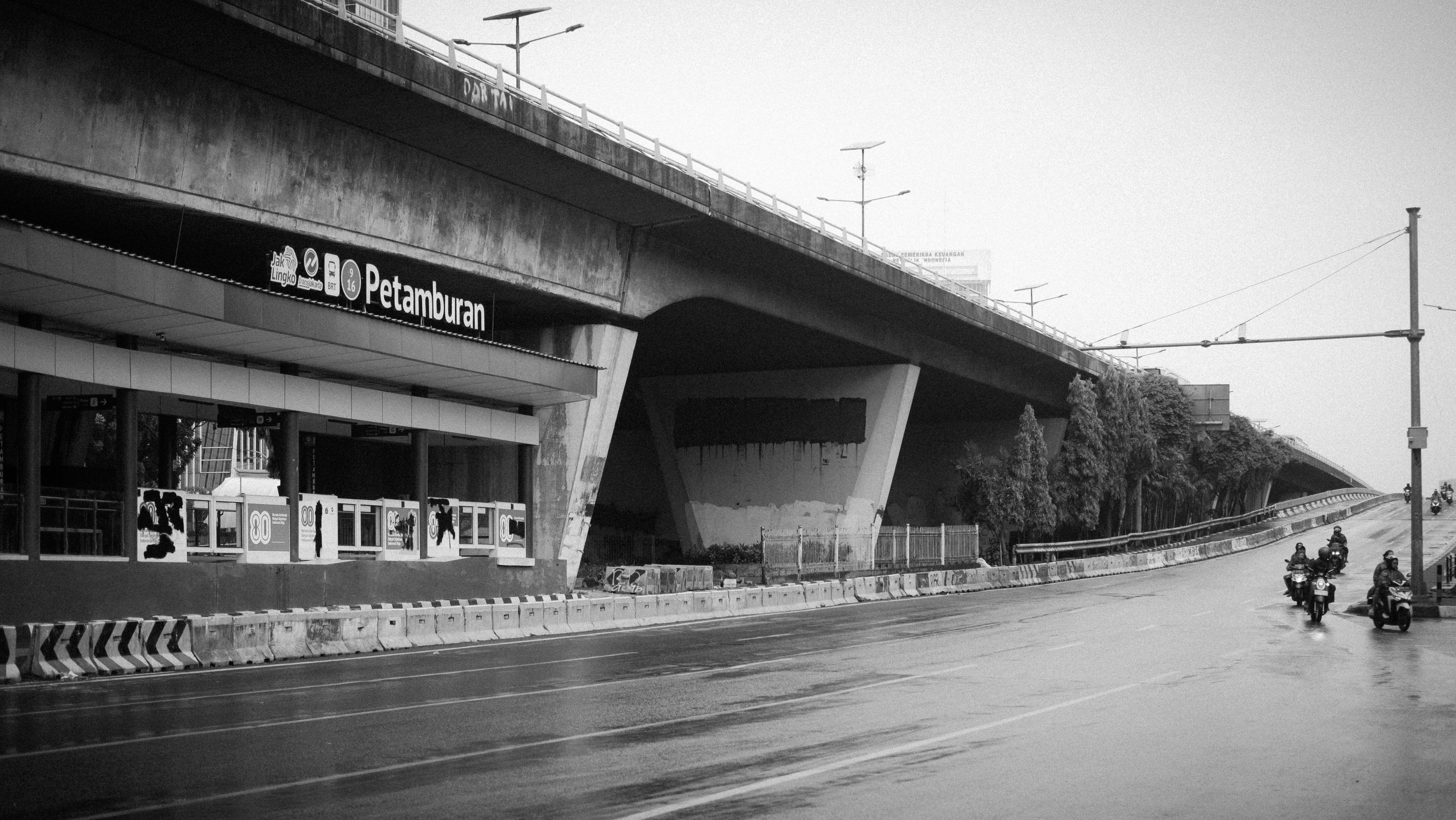 A monochrome scene depicting the Petamburan area, showcasing an elevated highway and a deserted street, creating a sense of solitude and urban stillness.