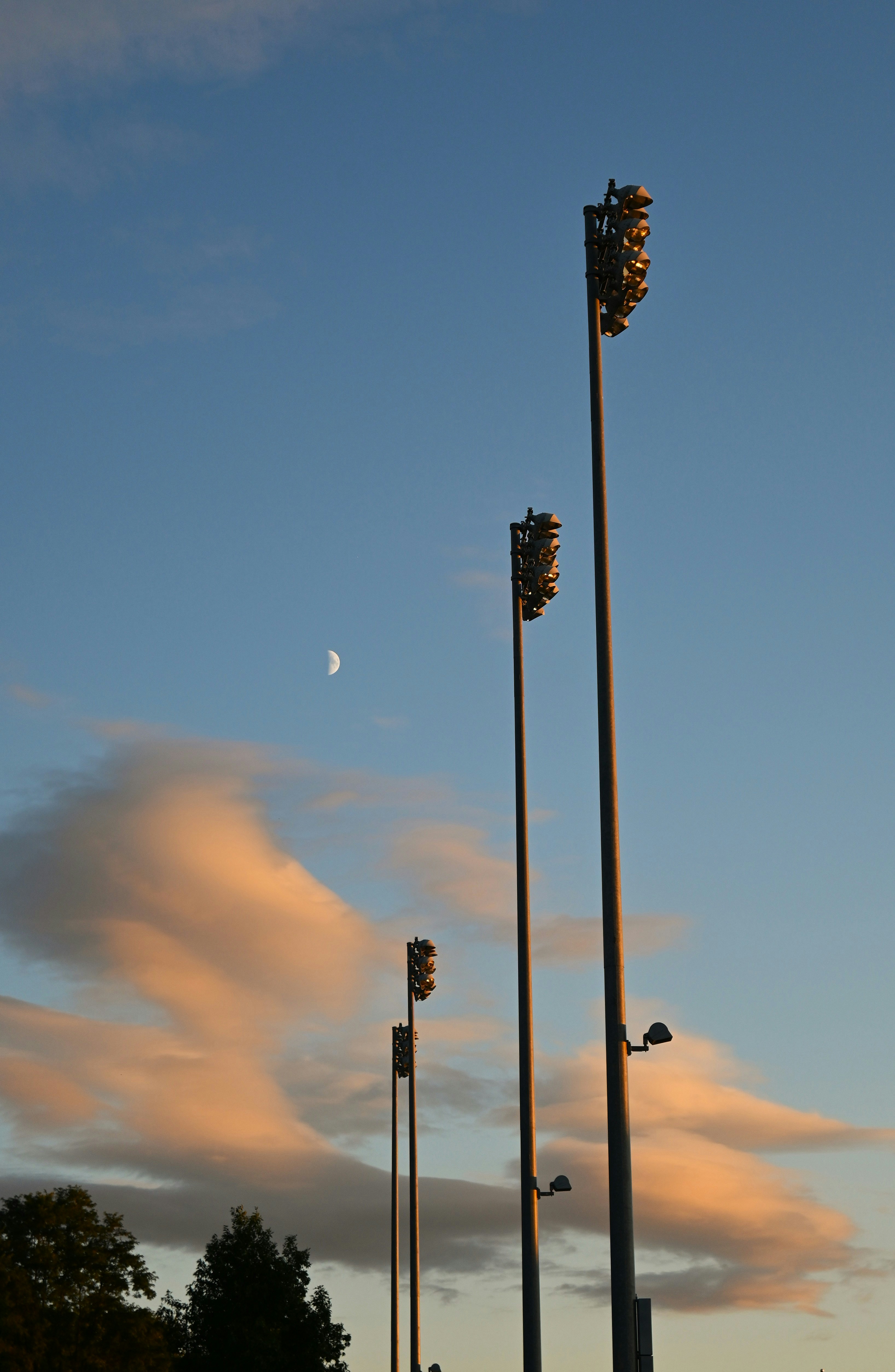 Tall stadium lights under a twilight sky