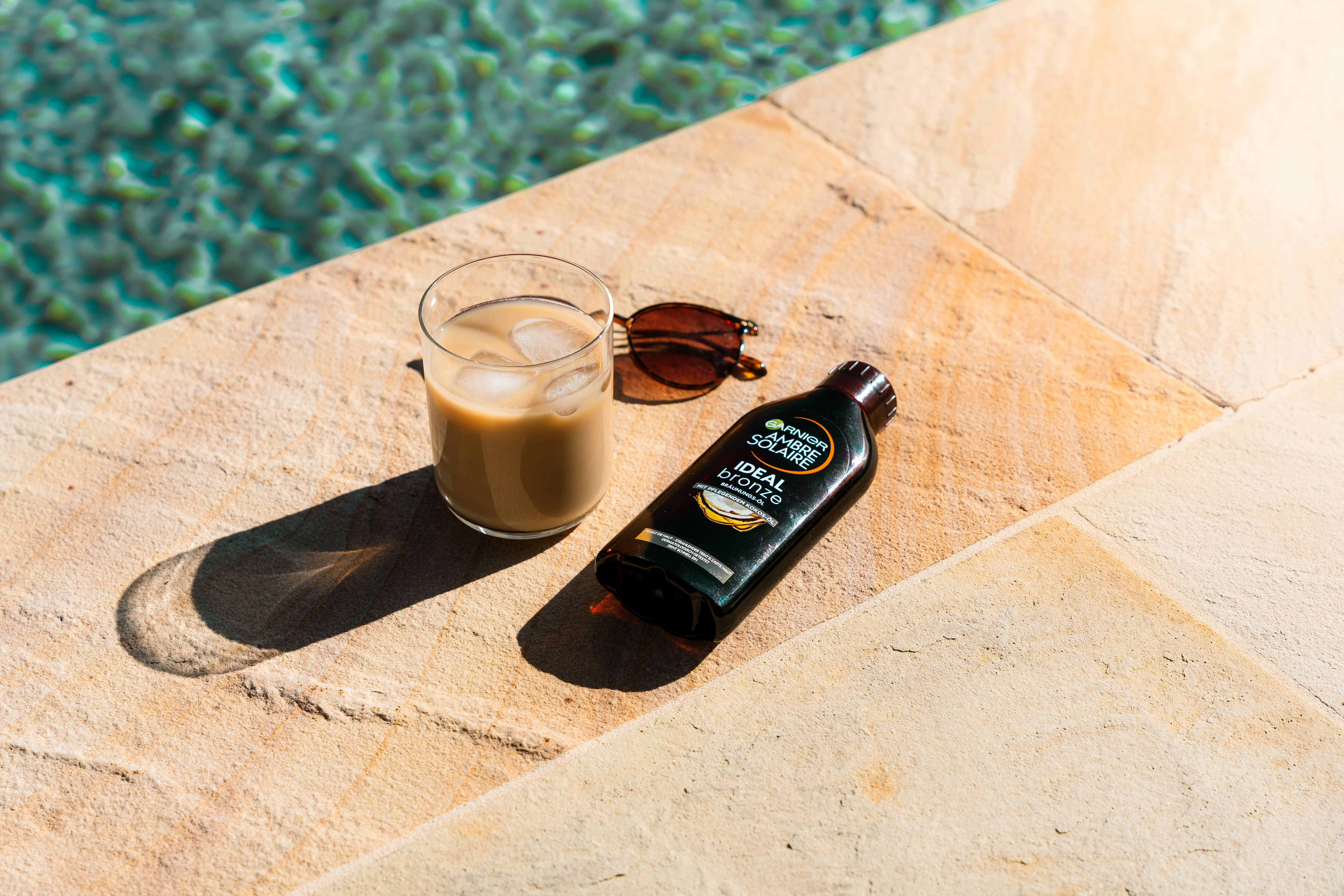 Sunlit Poolside Still-Life: Iced Coffee, Sunglasses, and Sunscreen