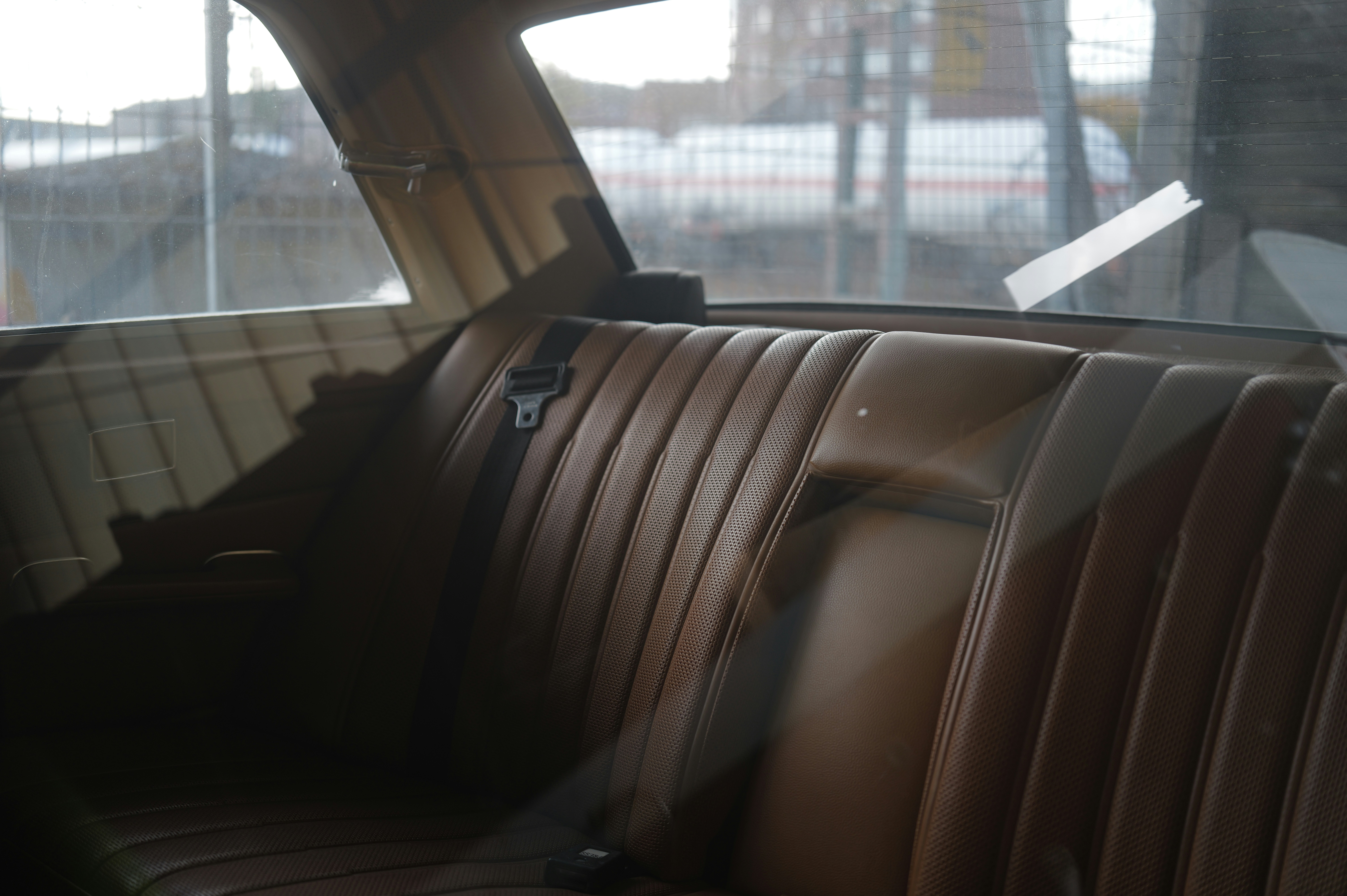Brown leather car seats with seatbelts visible.