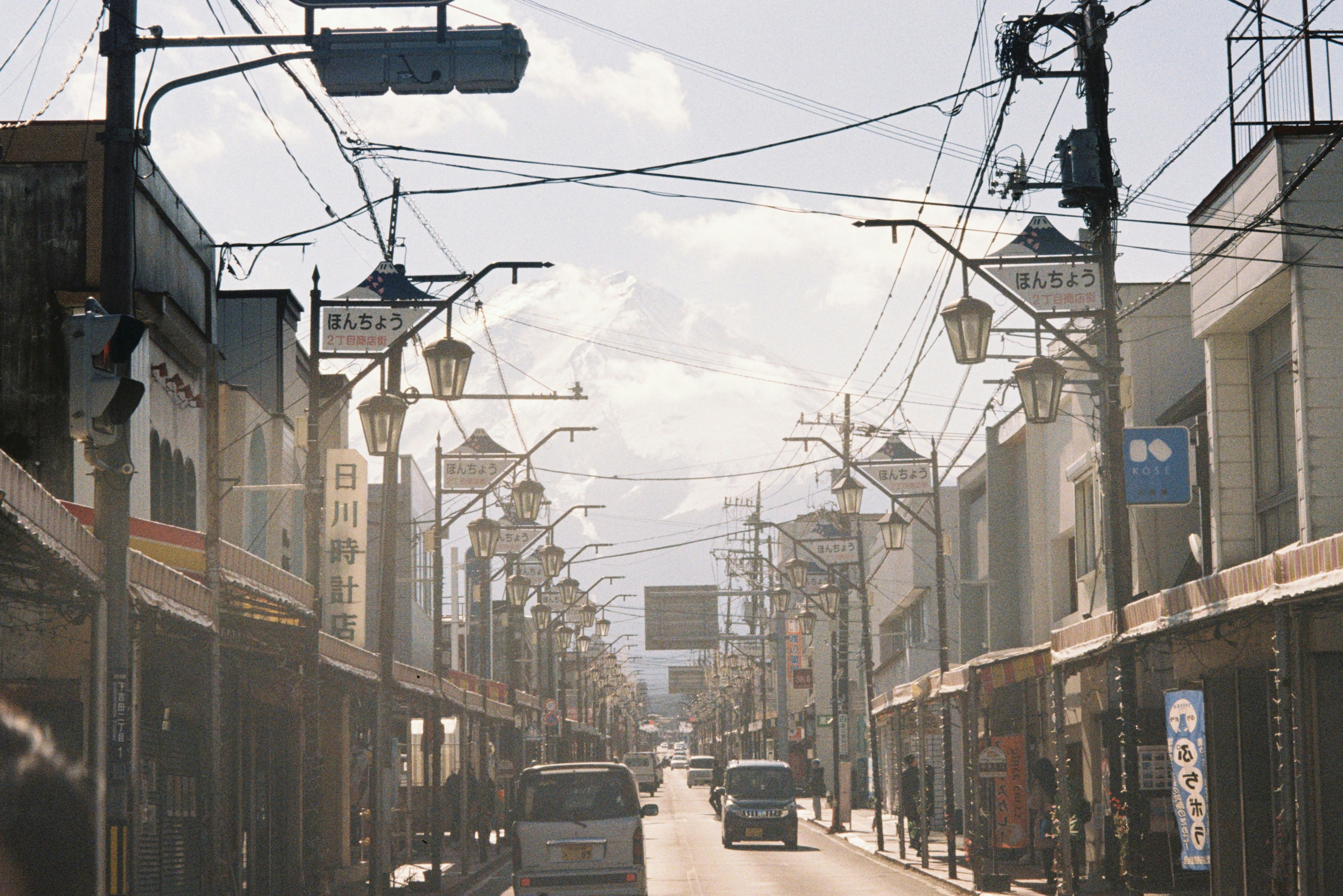 Street view of a japanese town with buildings and cars.