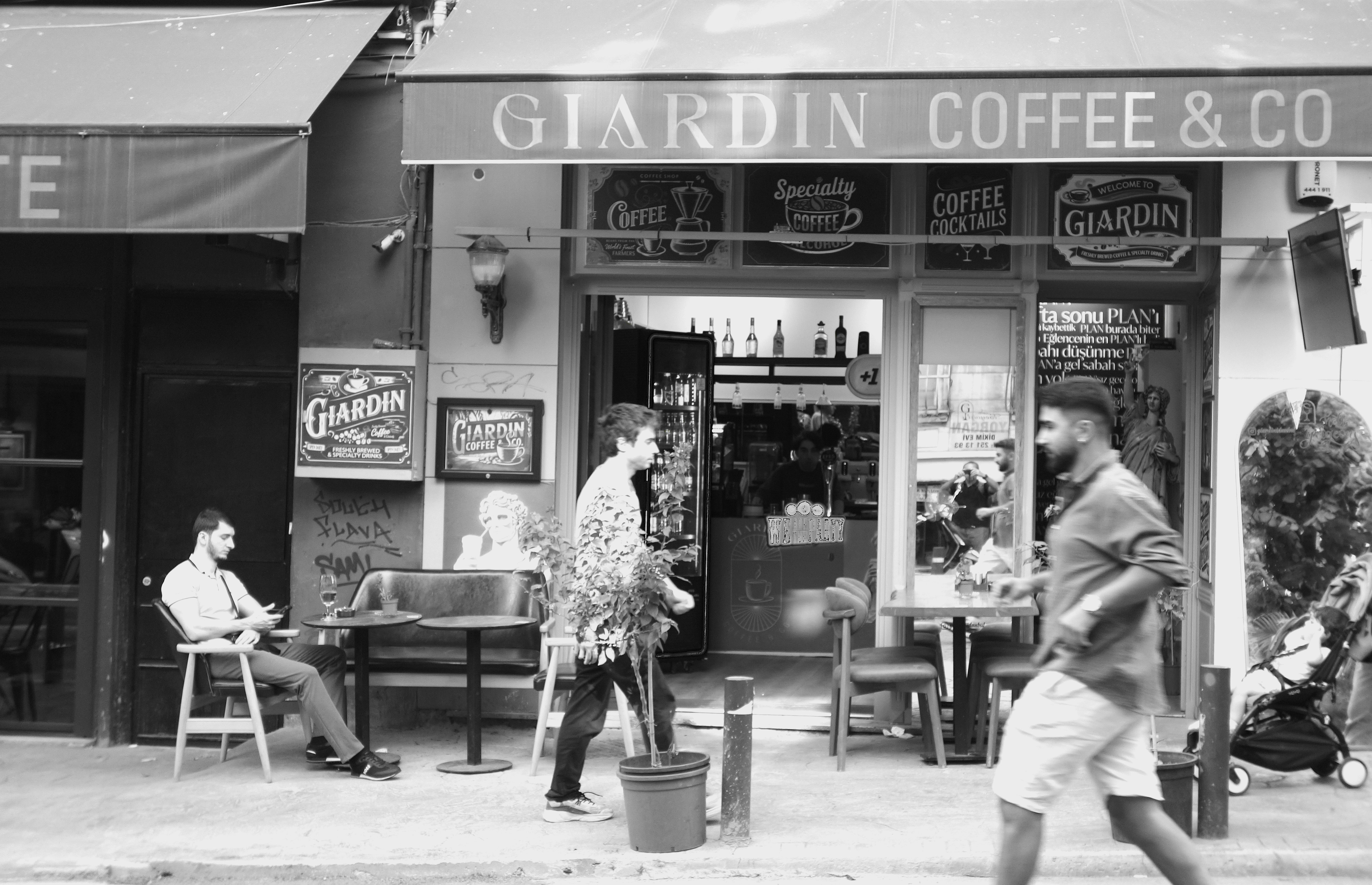 Cafe Front in Motion: A Quiet Street Moment Under Signage