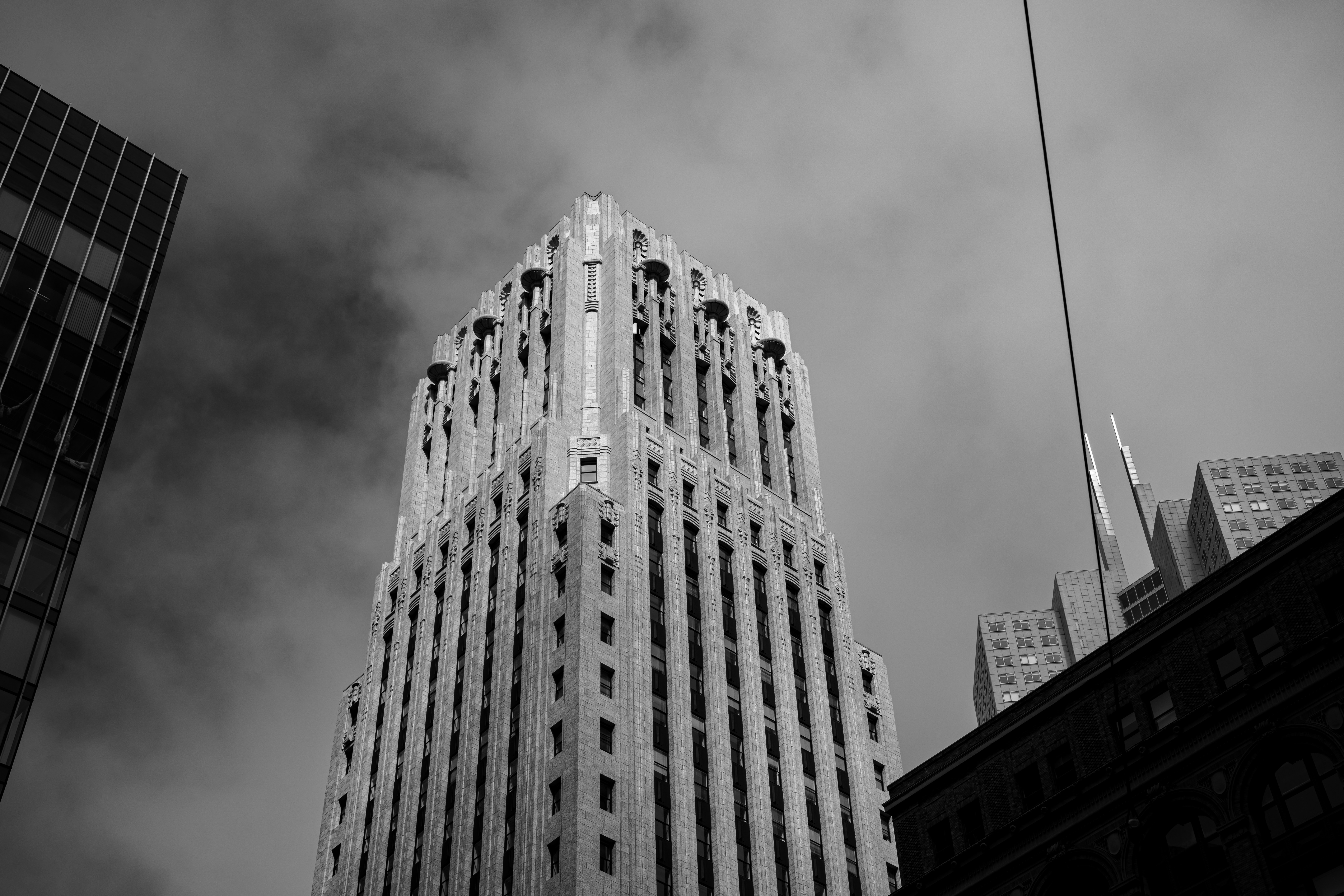Art Deco skyscraper rising against a moody sky, showcasing intricate detailing and historical significance.