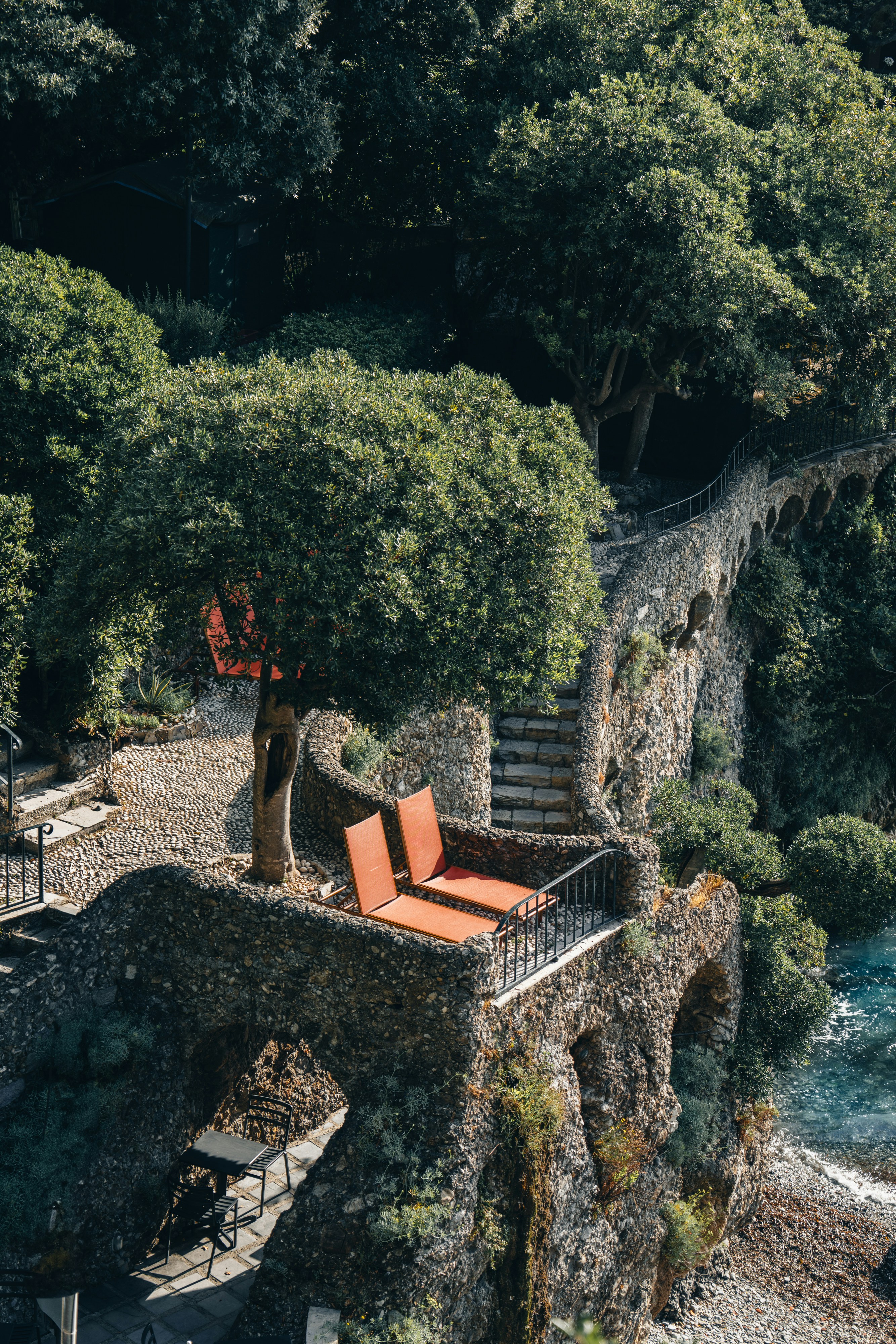 Stone bridge and seating area overlooking water photo – Free Beach ...