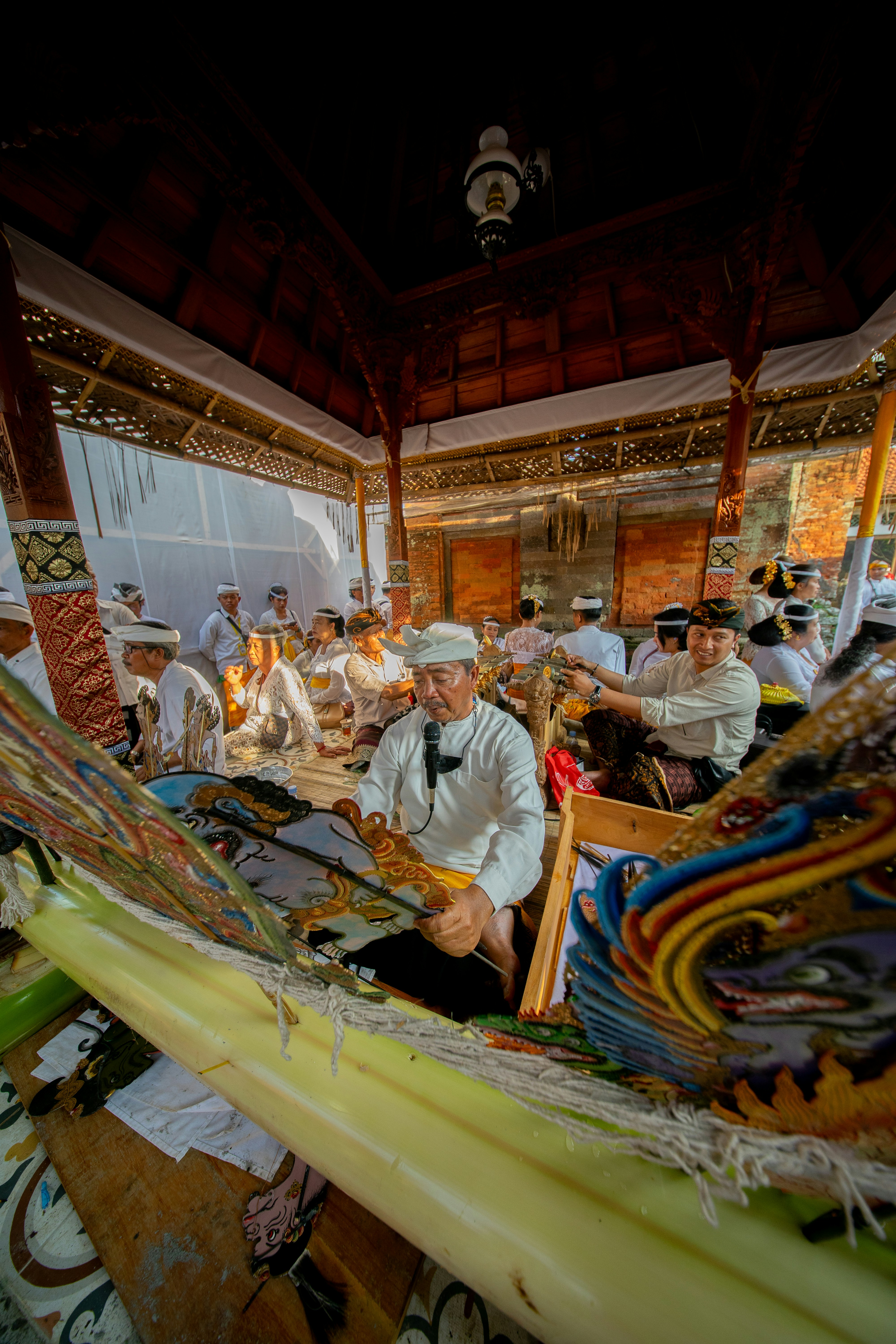 Bali Indonesia, August 23, 2025: The Peak Event of Karya Maliagia Puri Agung Bangli. The culmination of the Karya Maligia Punggel event at Puri Agung Bangli, Bali, is scheduled for Saturday Pahing Kelawu, August 23, 2025. This event is a large-scale ceremony aimed at spiritual purification, marked by processions such as the making of Sanganan Suci and pecaruan. What is Karya Maligia Punggel? This is a religious ceremony included in the Karya Utamaning Utama category. Its purpose is physical and spiritual cleansing, namely the purification of the Five Dimensions (Panca Tan Matra) to return the | Men in traditional attire working on colorful puppets.