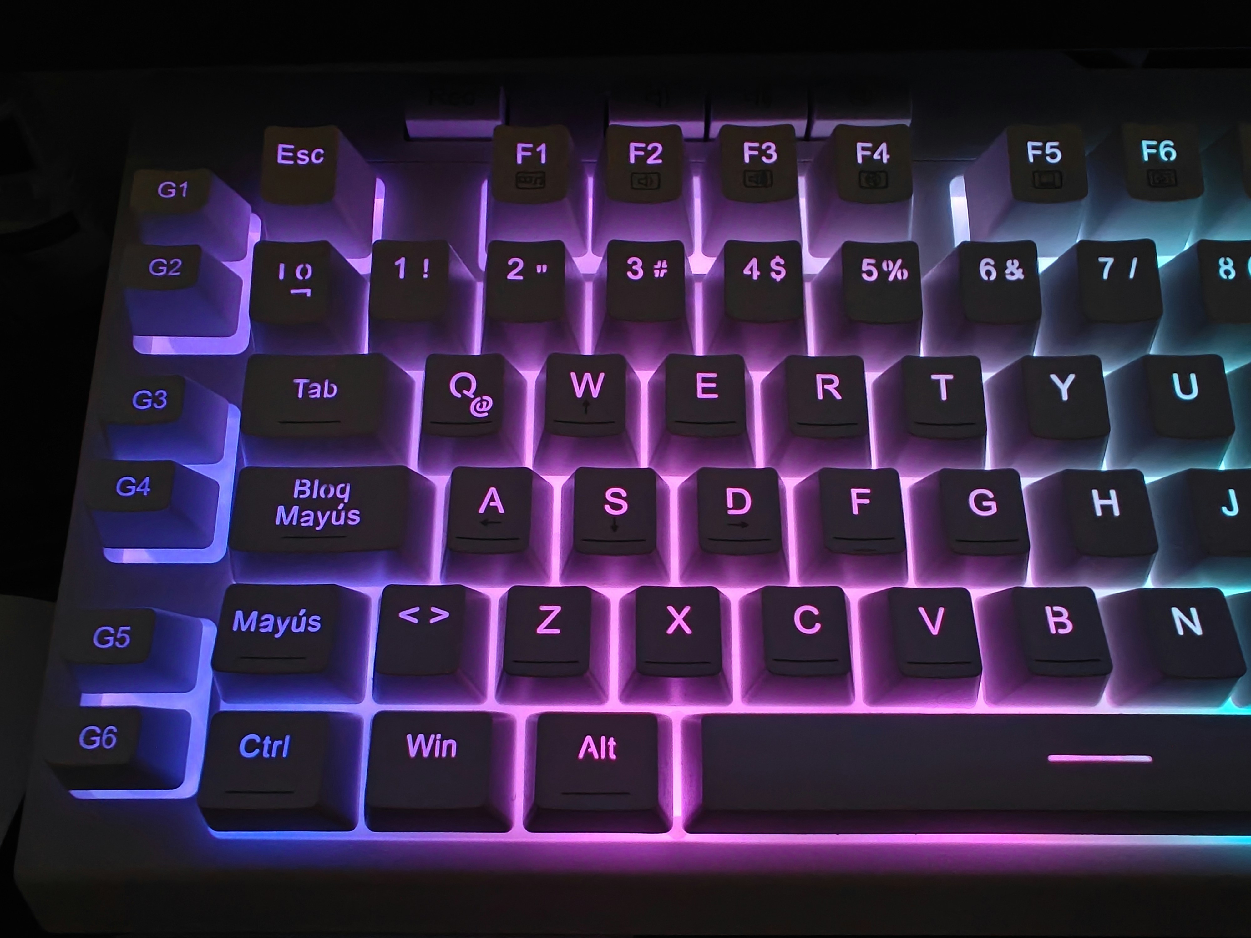 A white keyboard with colorful rgb backlighting.