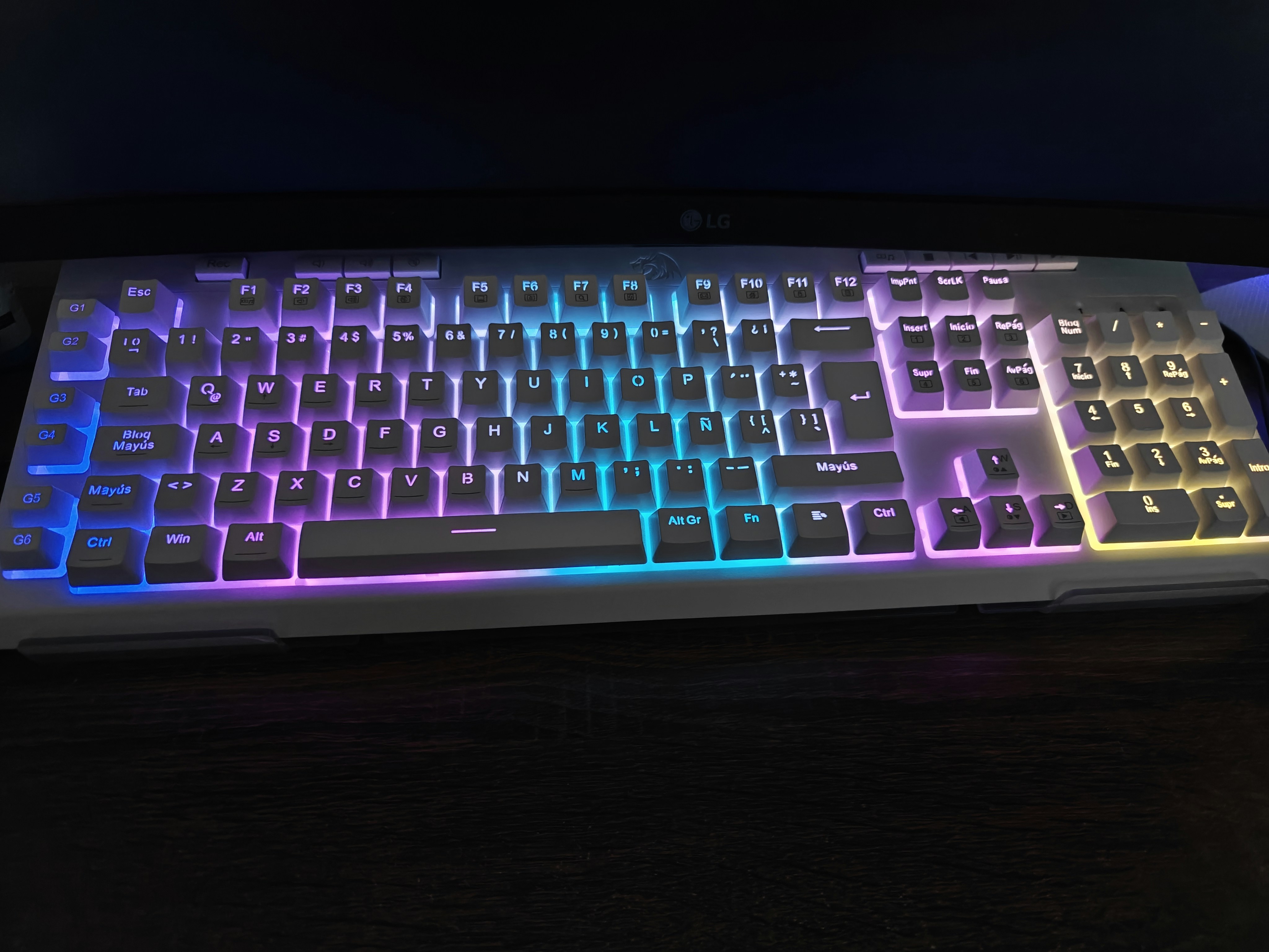 RGB mechanical keyboard with vibrant lighting effects, showcasing a blend of colors against a dark background.