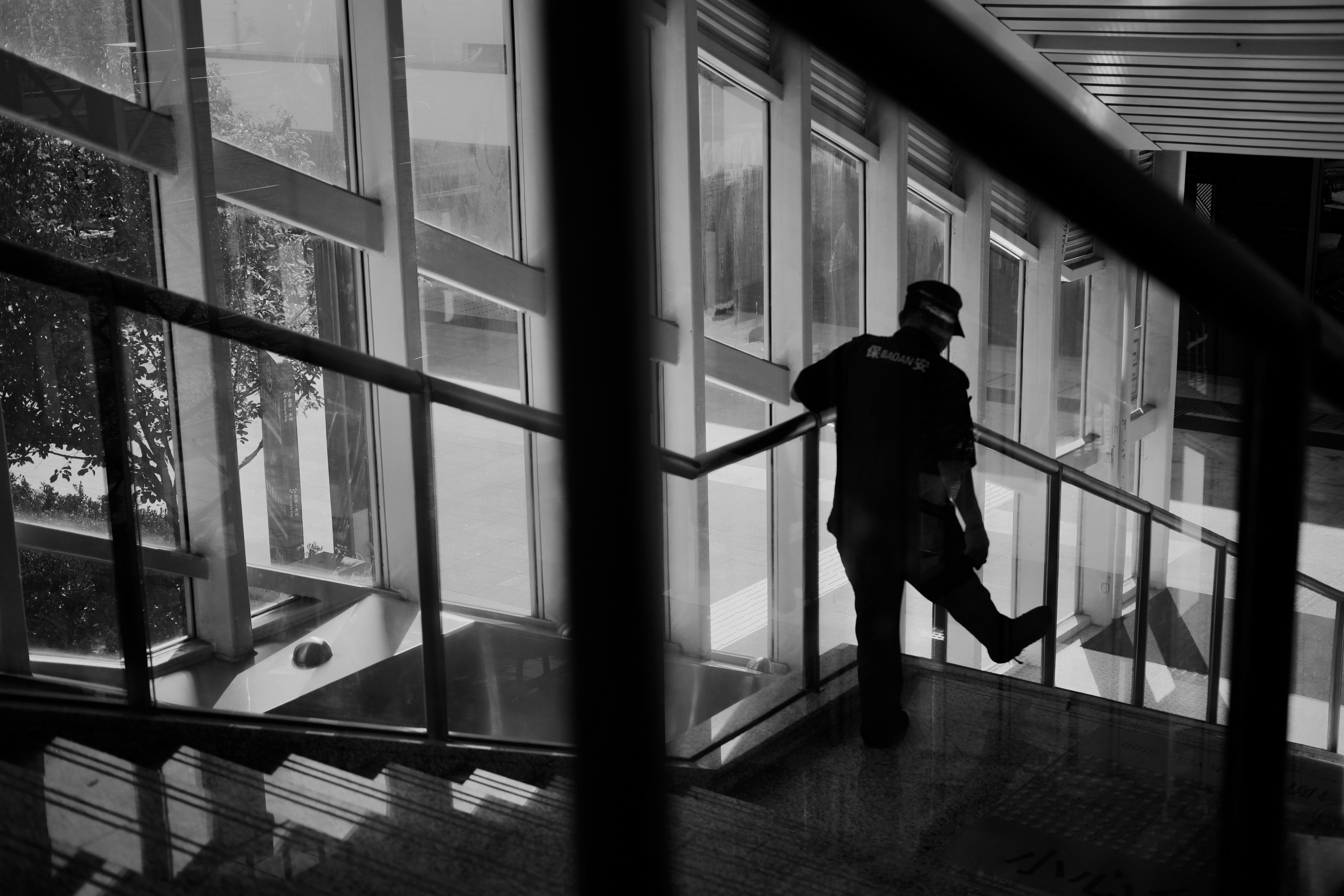Man walking down stairs next to windows