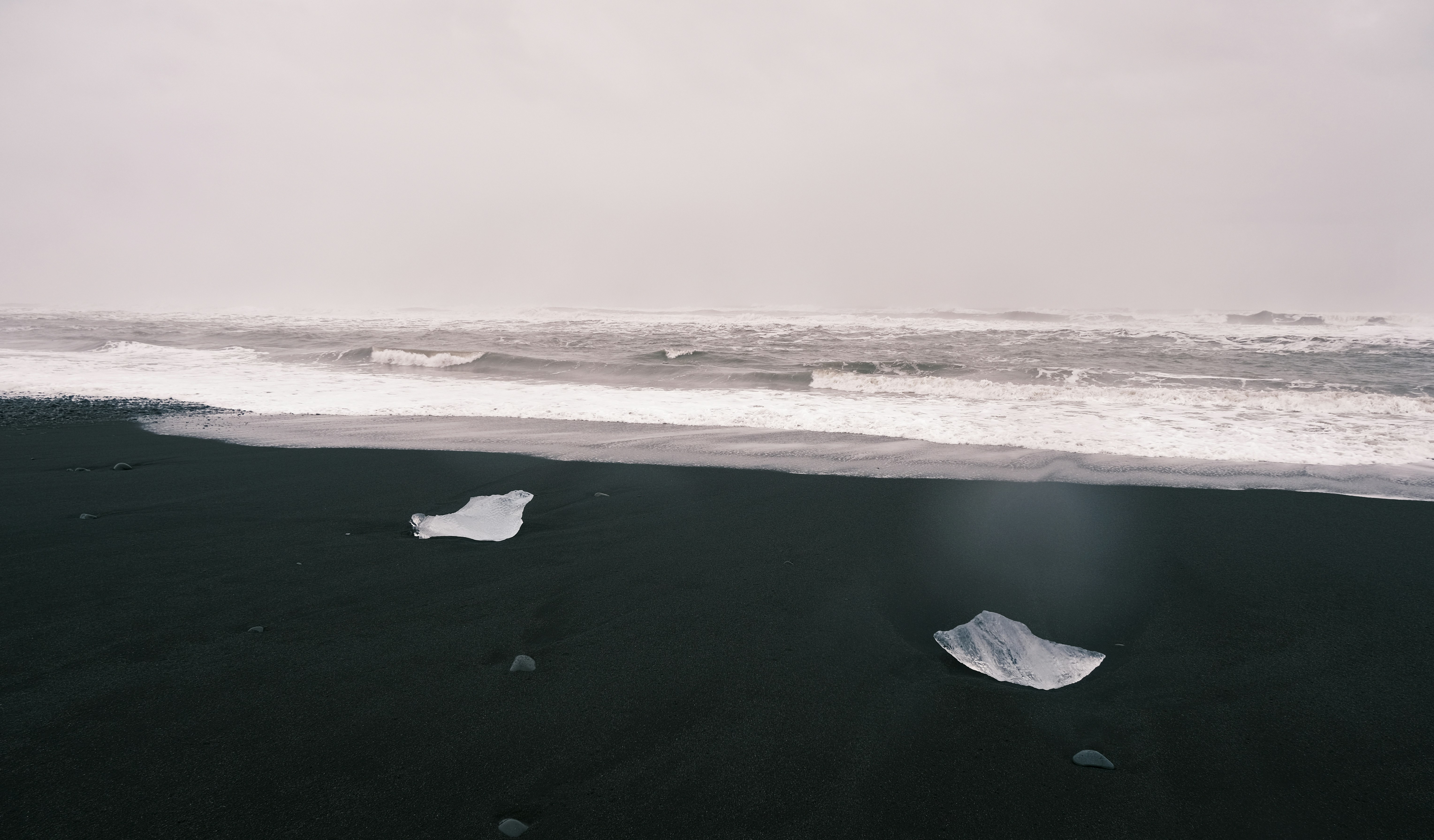 Small ice chunks float in dark water photo – Free Black sand beach ...