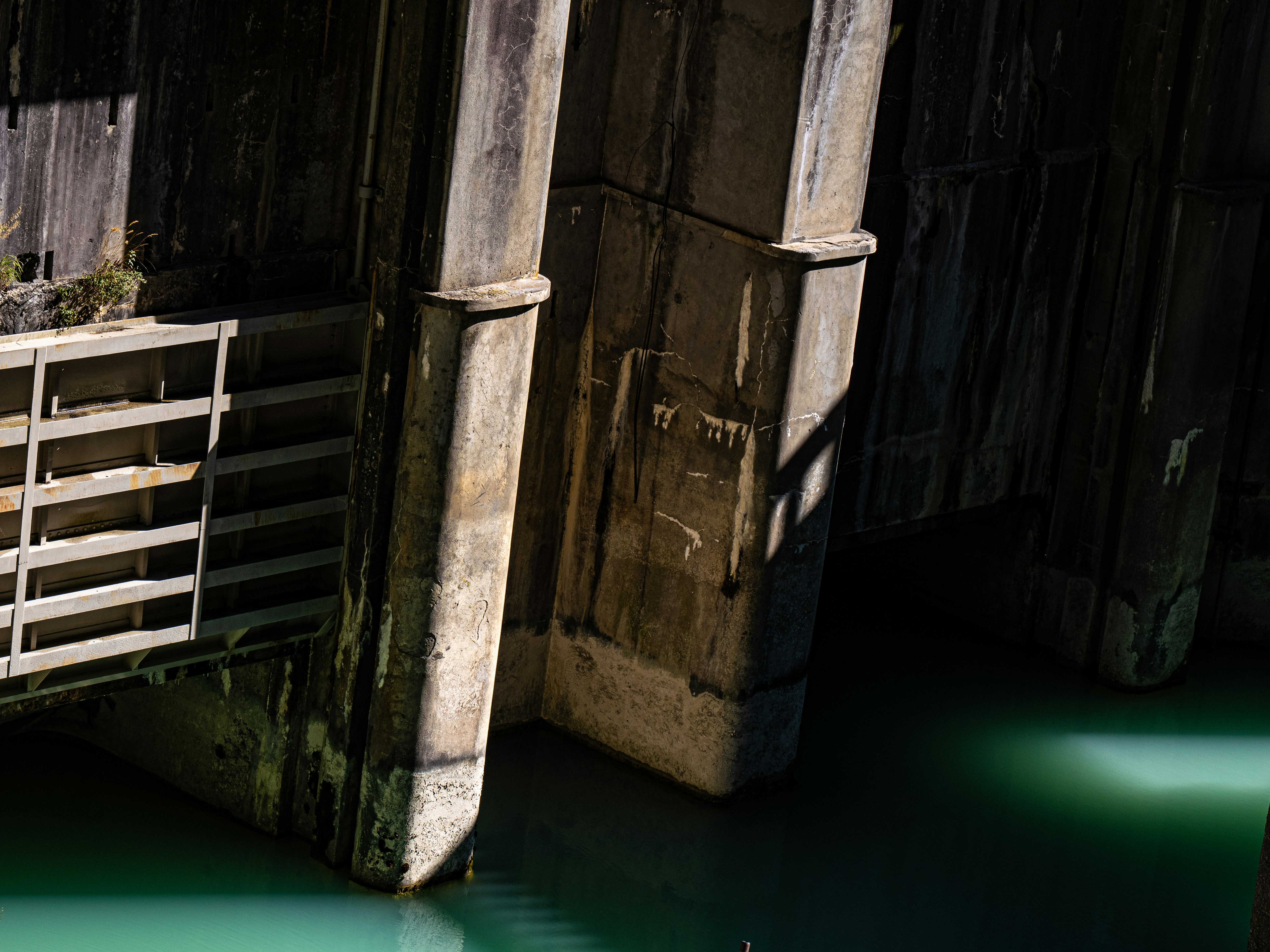 Massive concrete structures rise above turquoise water.