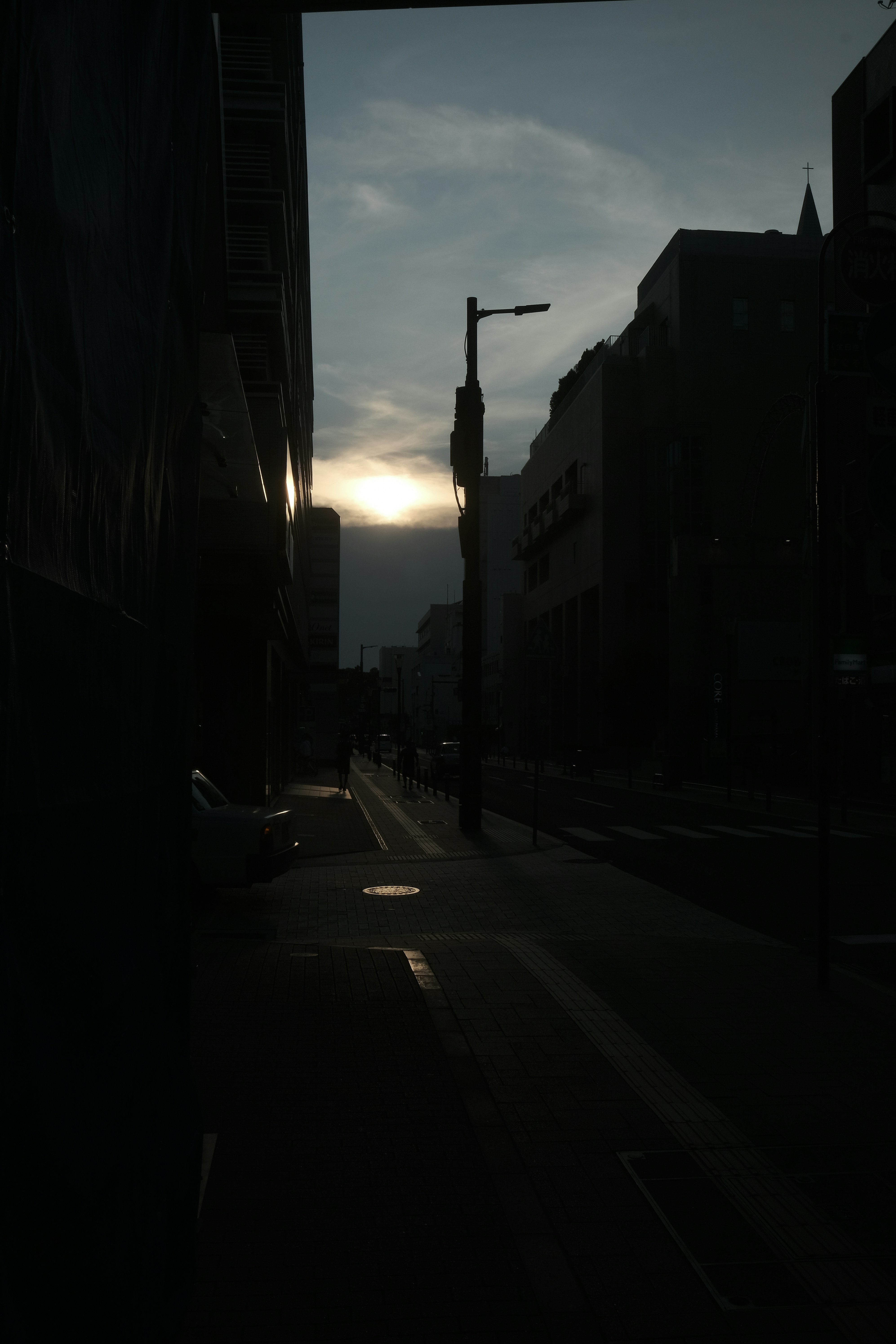 City street at dusk with buildings and lamp post.
