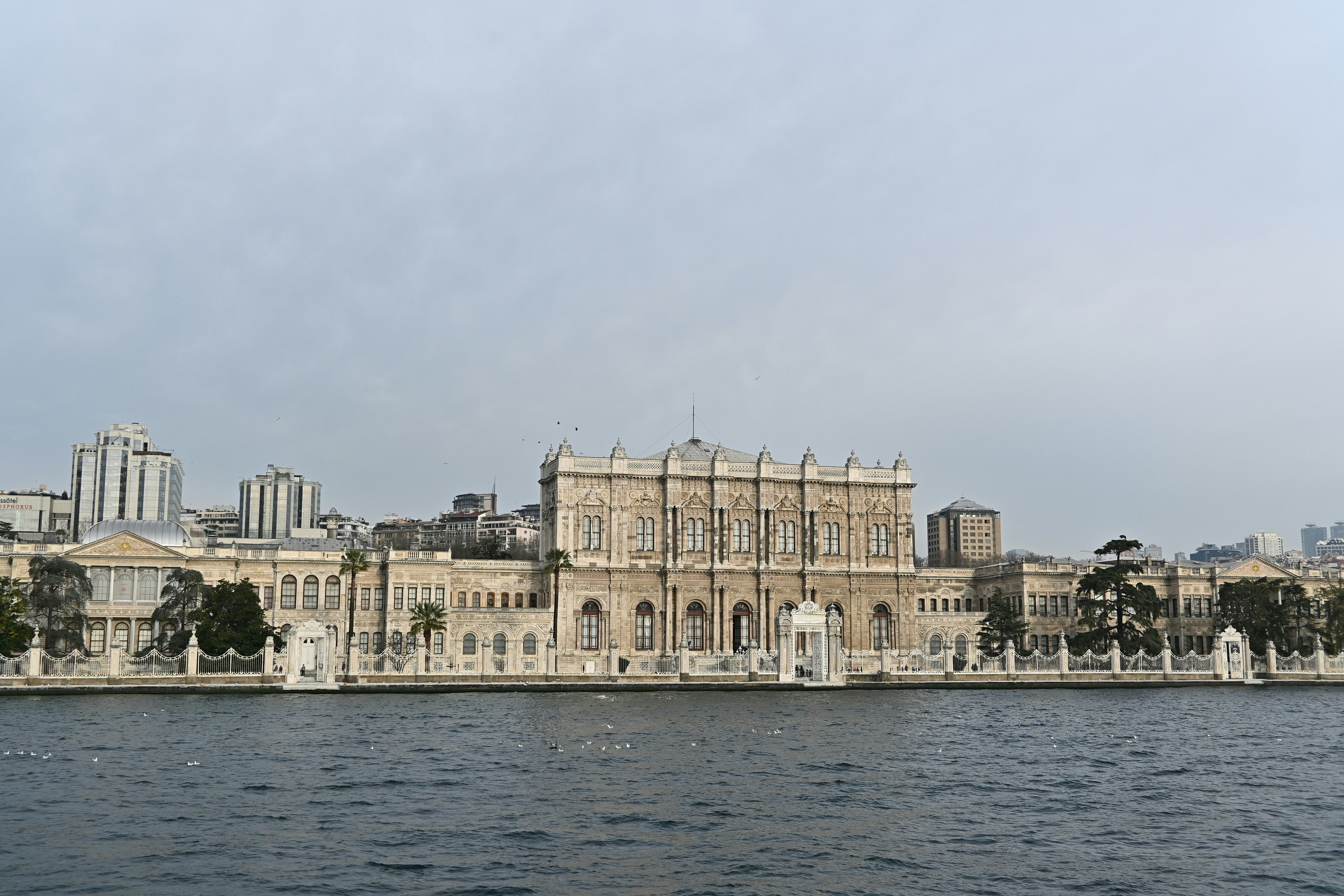 Grand palace on a waterfront with city buildings behind photo – Free ...