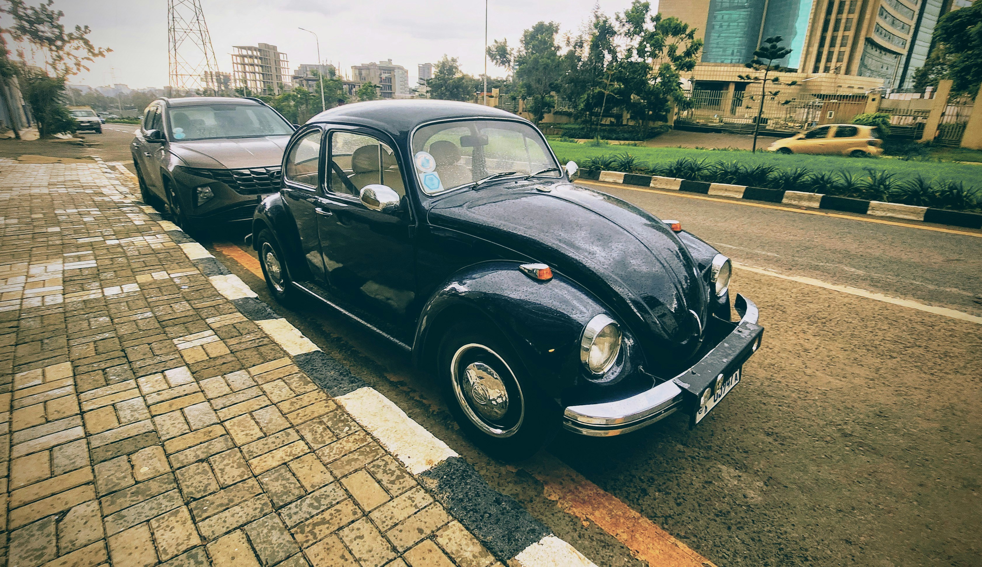 A timeless black Volkswagen Beetle parked on a wet city street, capturing a nostalgic vibe amidst modern surroundings. The reflections on the car and pavement add a vintage charm to the urban landscape. | Classic black volkswagen beetle parked on street.