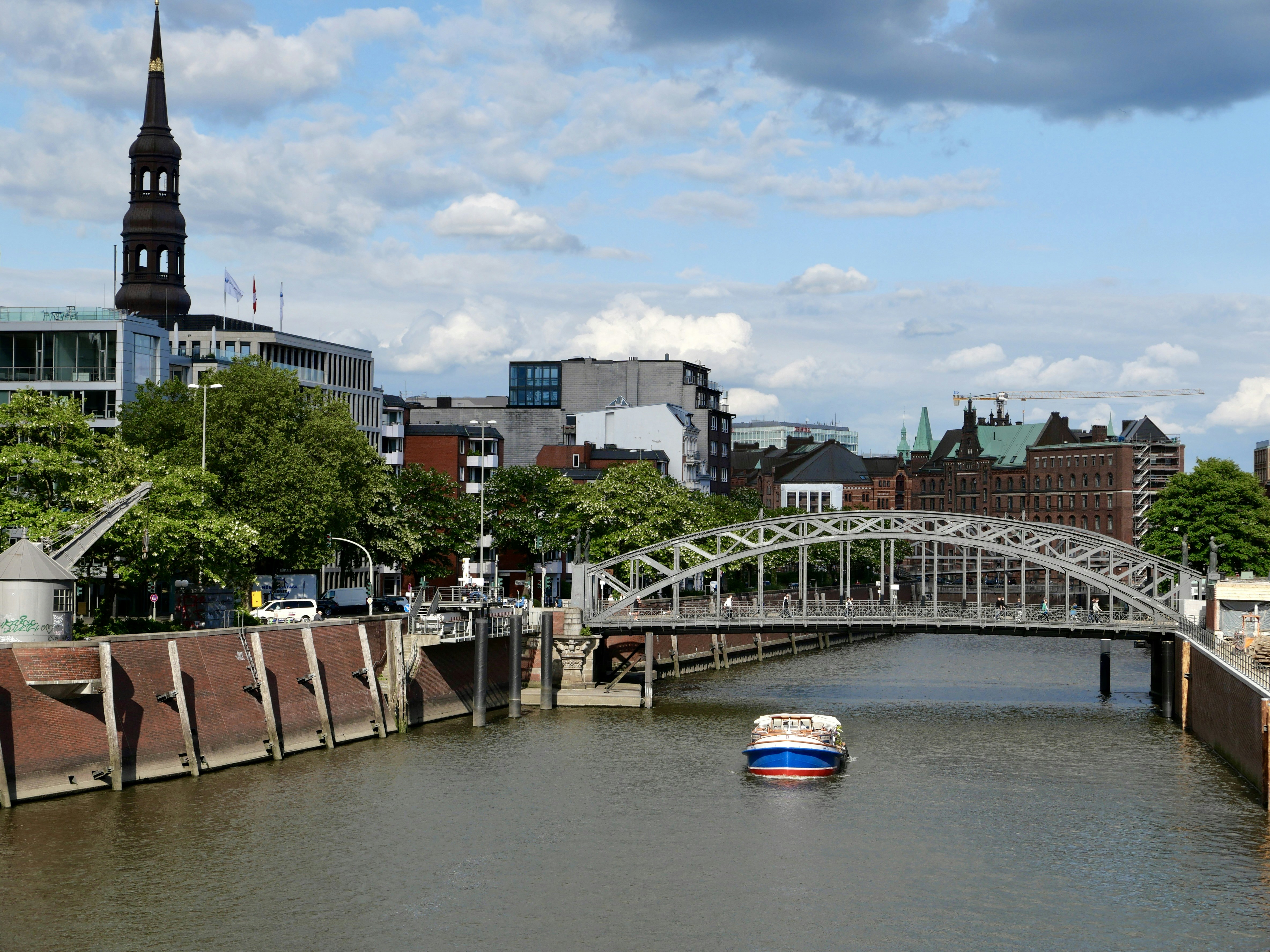 Boat on a canal with a bridge and city buildings