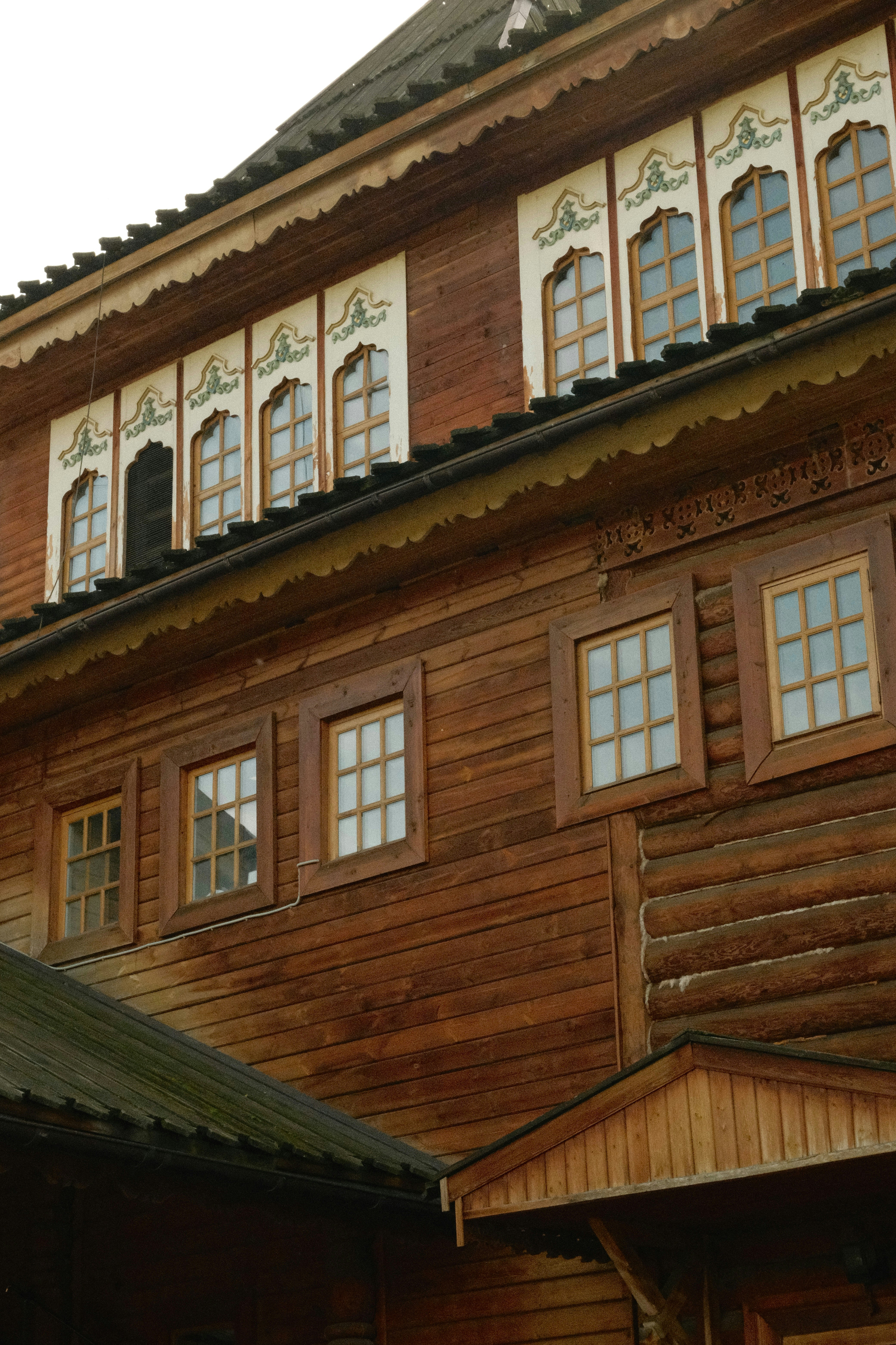 Intricate wooden facade of a traditional building showcasing ornate windows and detailed craftsmanship.