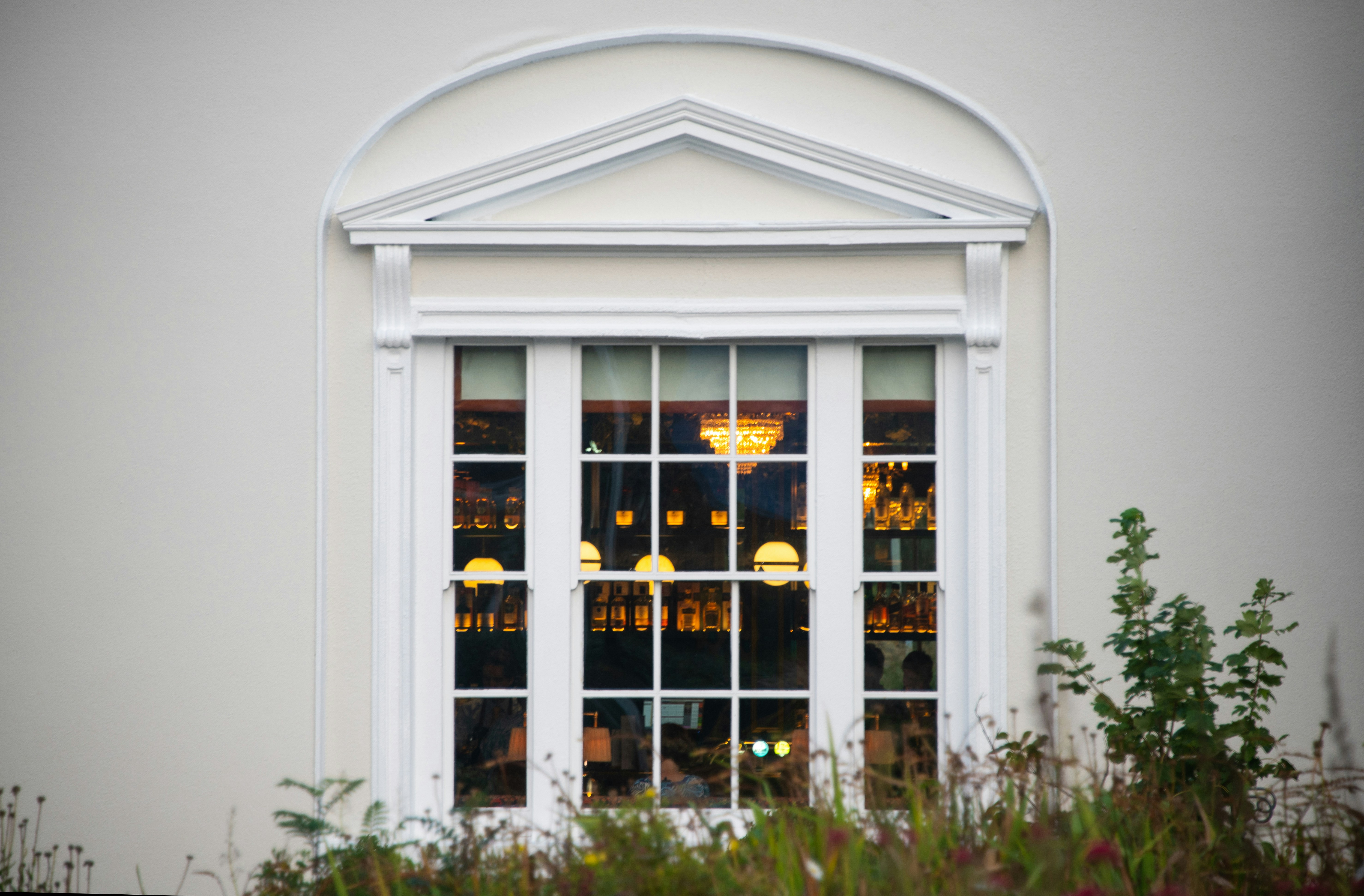 Large window reflecting lights of a building interior.
