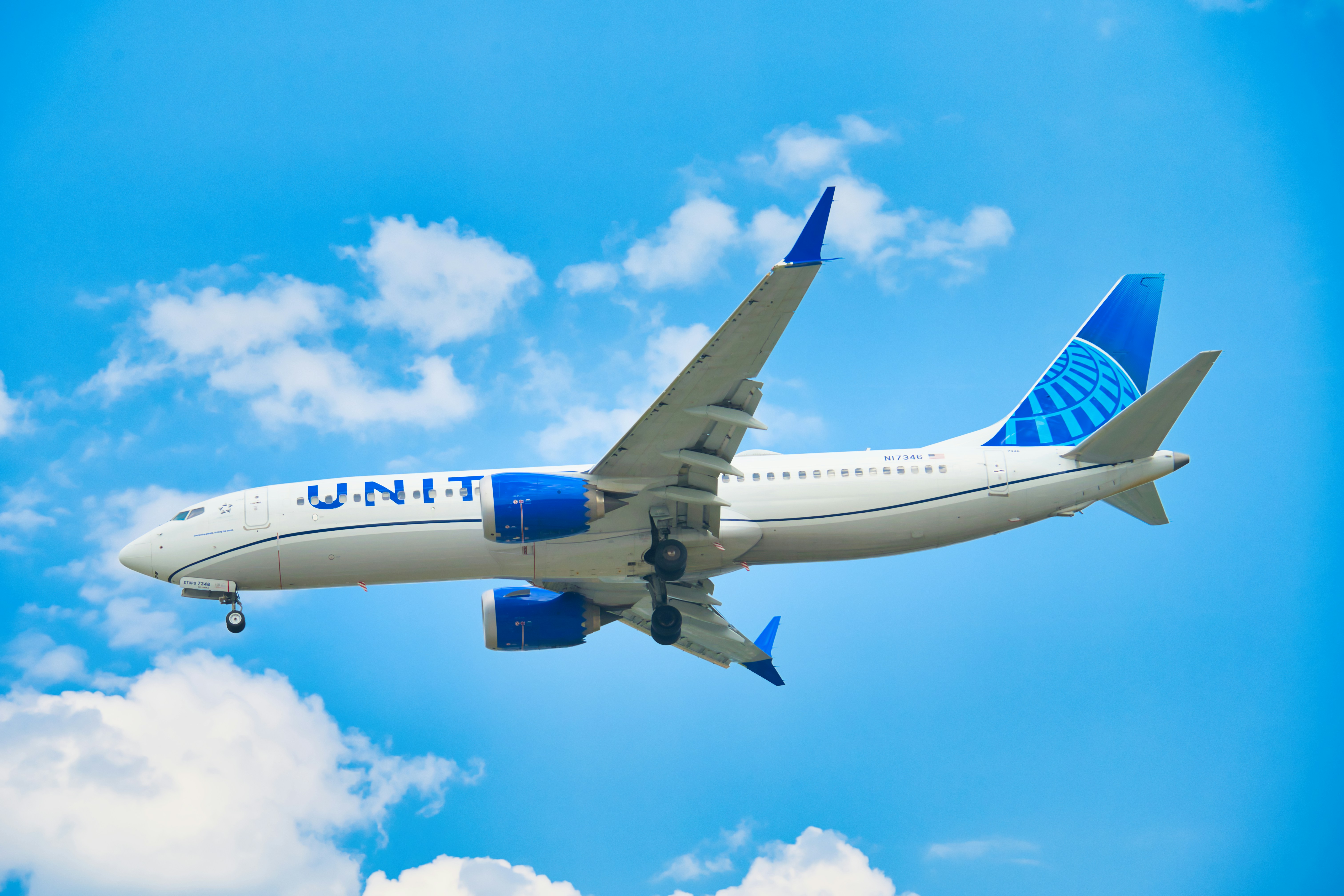 United Airlines jet tracing a sapphire arc across a pristine sky