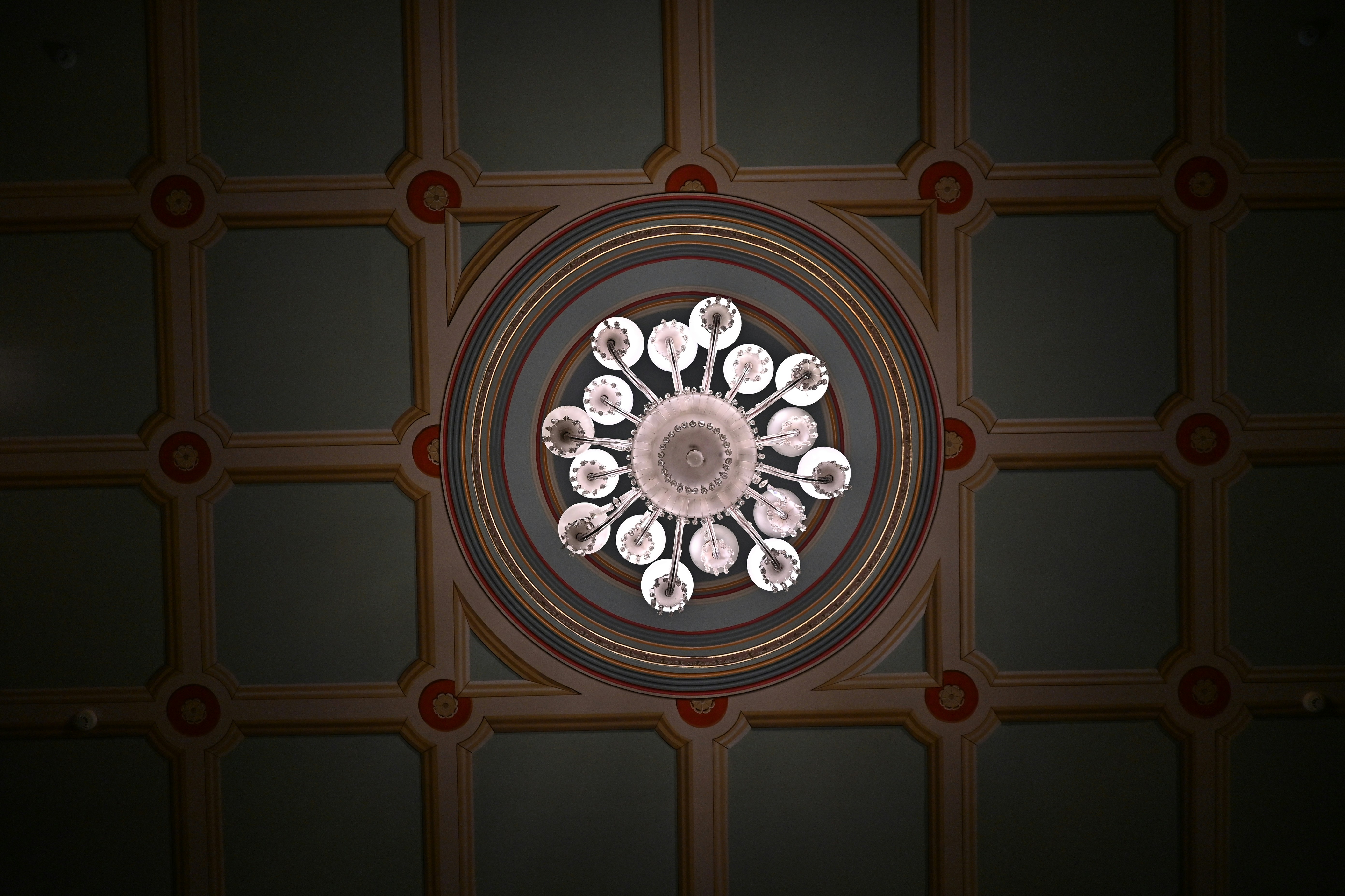 Ornate chandelier hanging from a decorative ceiling.