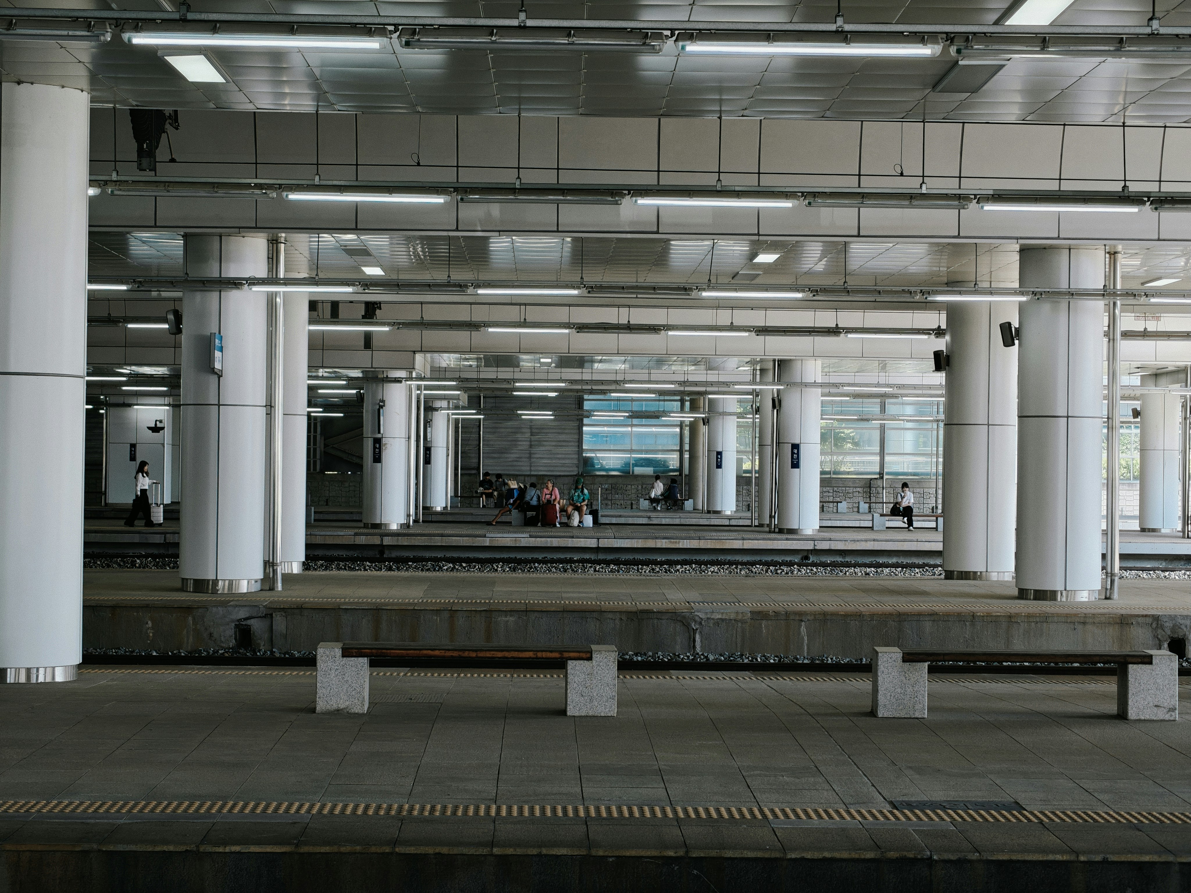 Awaiting. | Modern train station with people waiting on platform