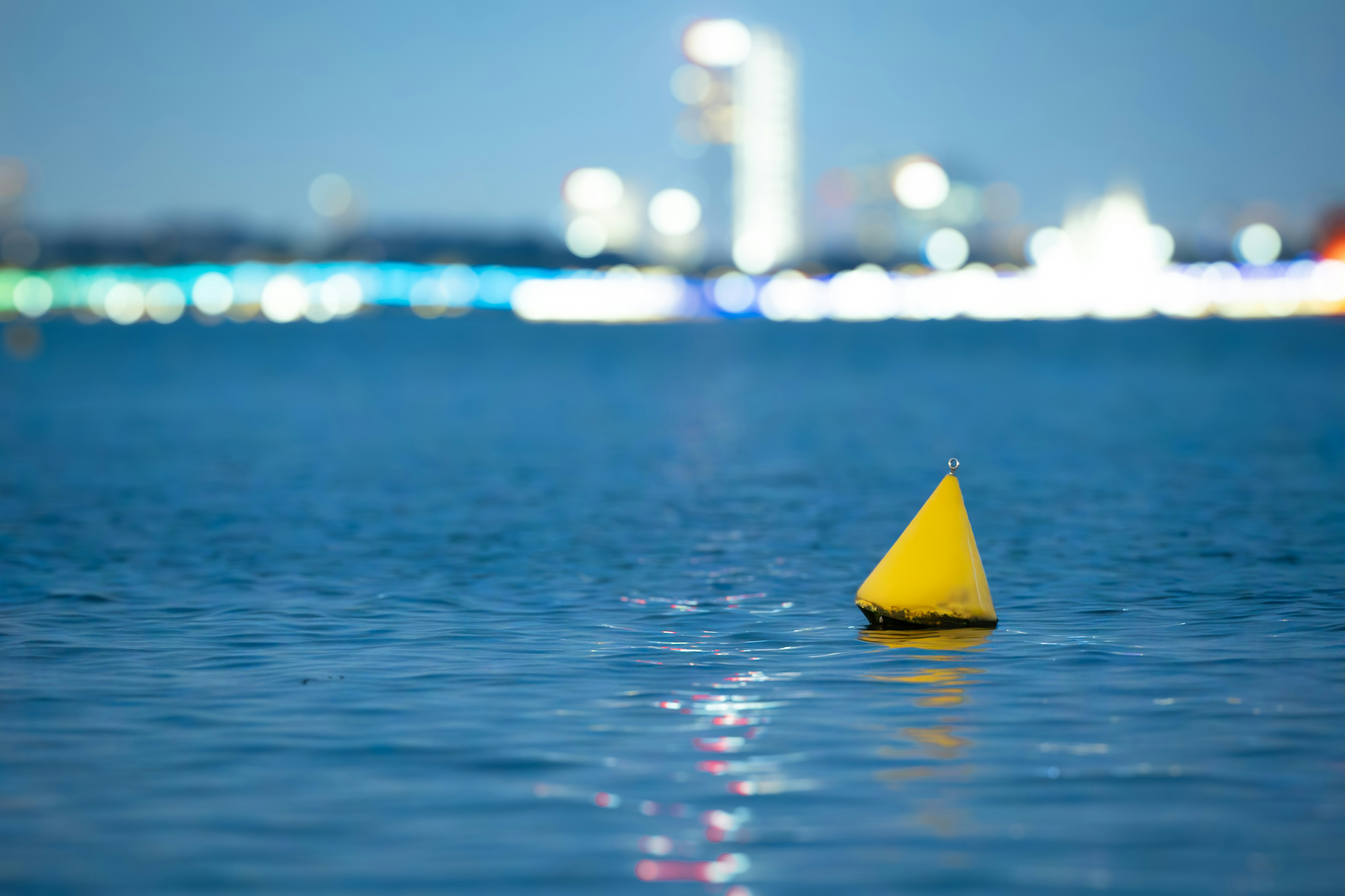 Yellow Buoy in a Velvet Blue Harbor with Neon City Lights