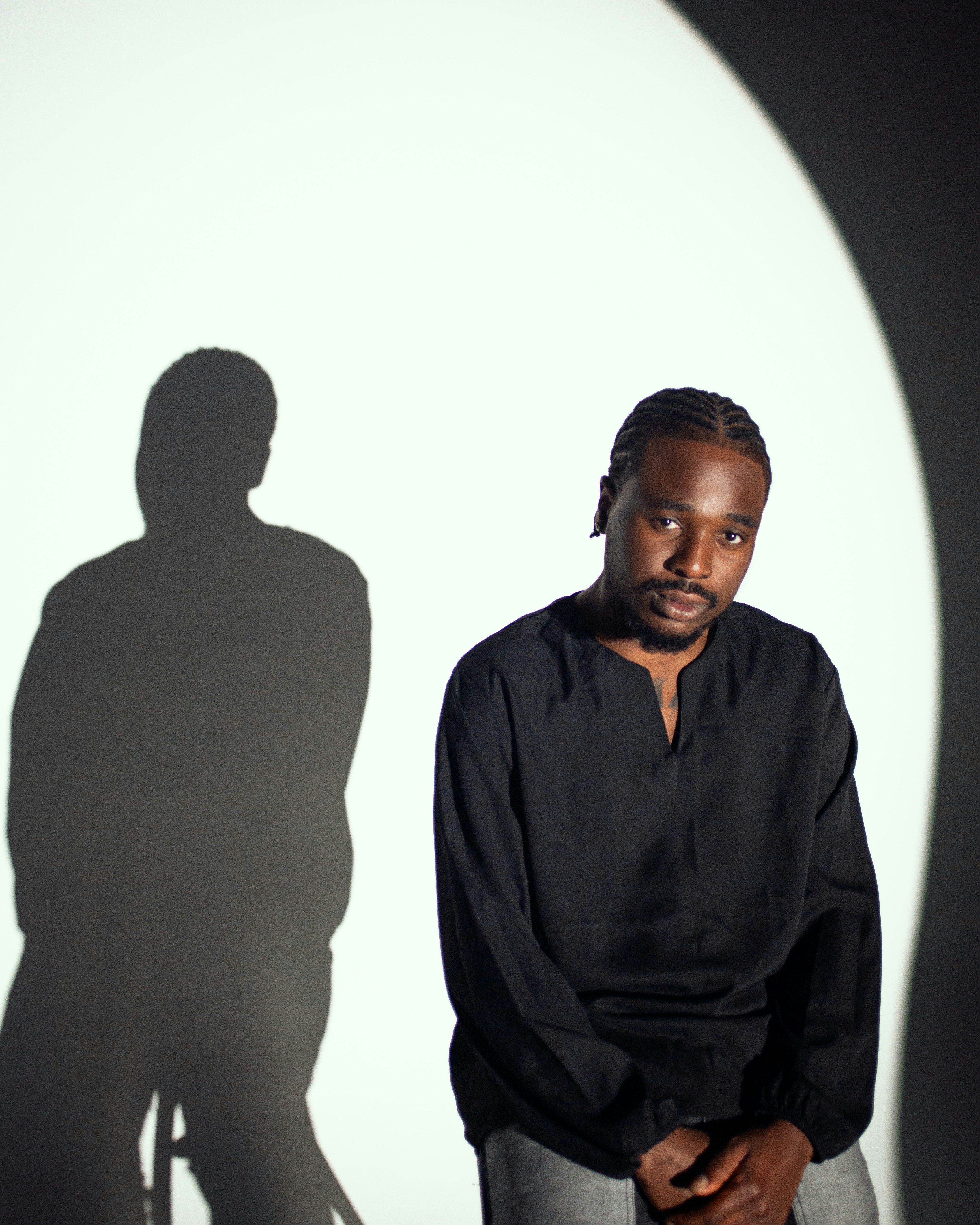 Man sitting with shadow on white background
