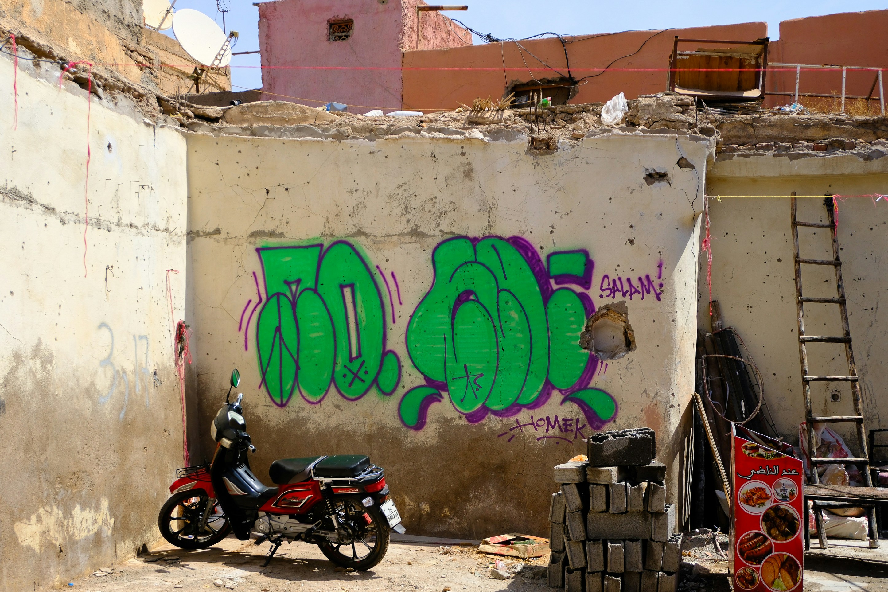 Graffiti art on a weathered wall with a motorcycle.