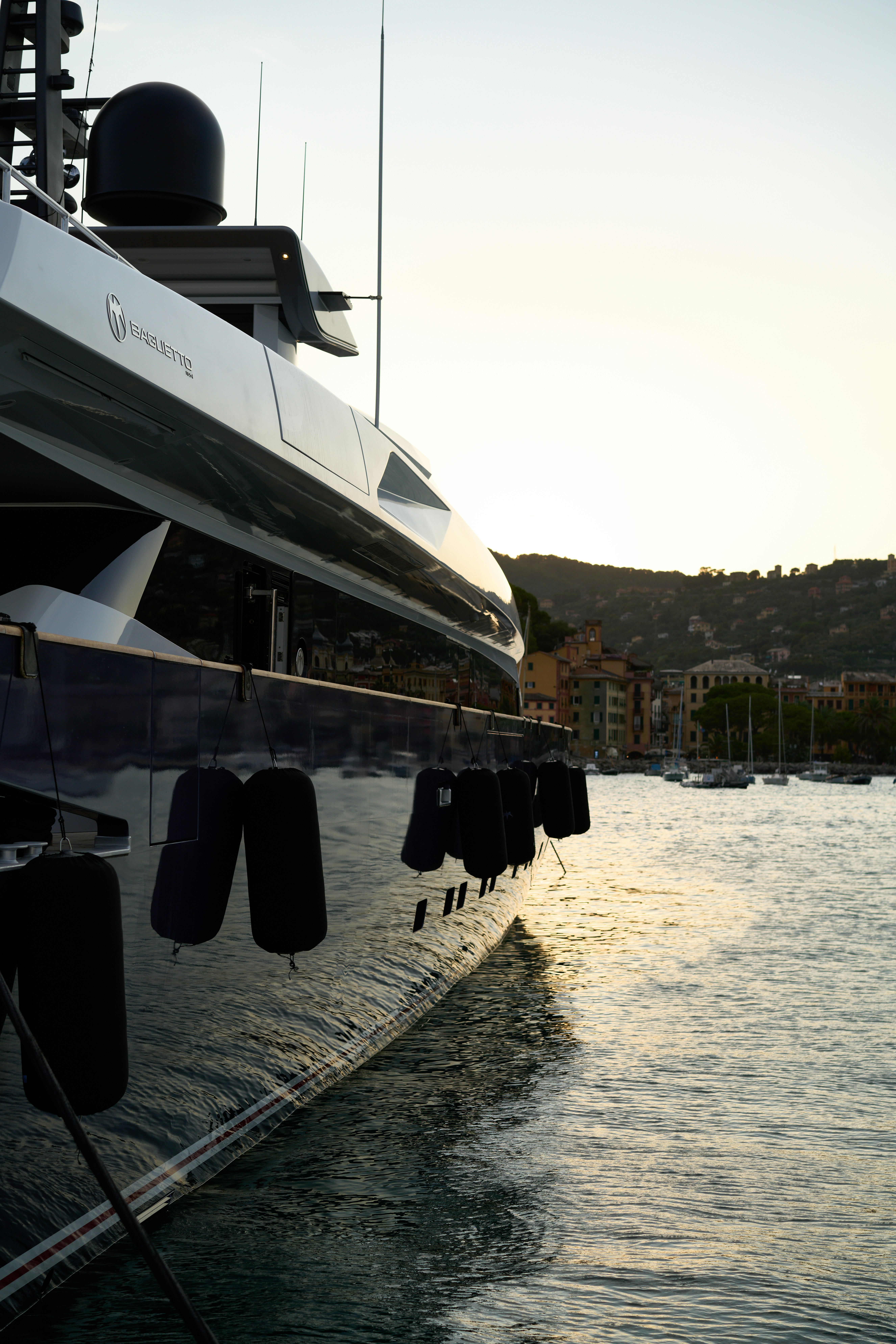 Large yacht docked with fenders hanging overboard.
