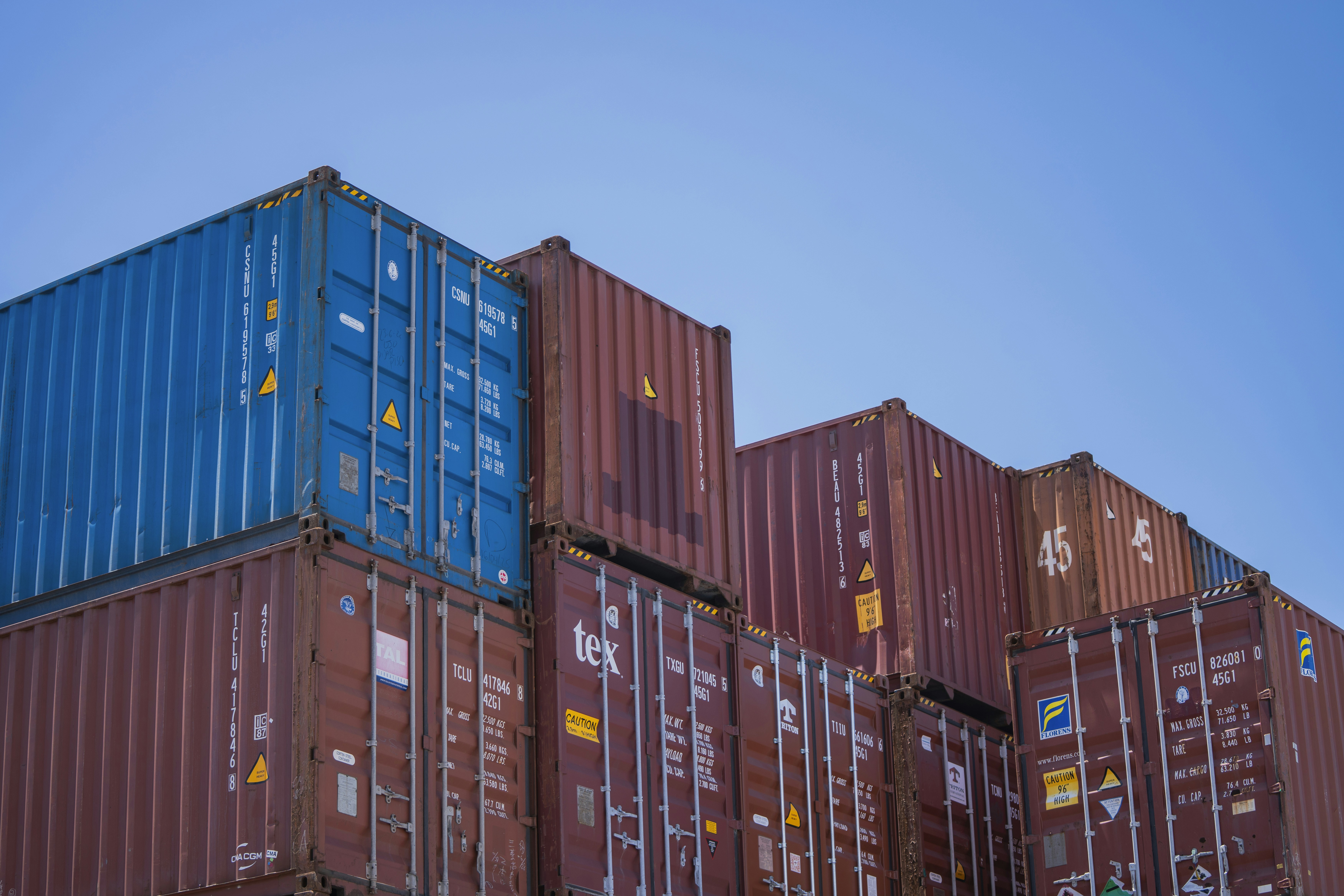 Stack of shipping containers against a blue sky photo – Free Marin ...