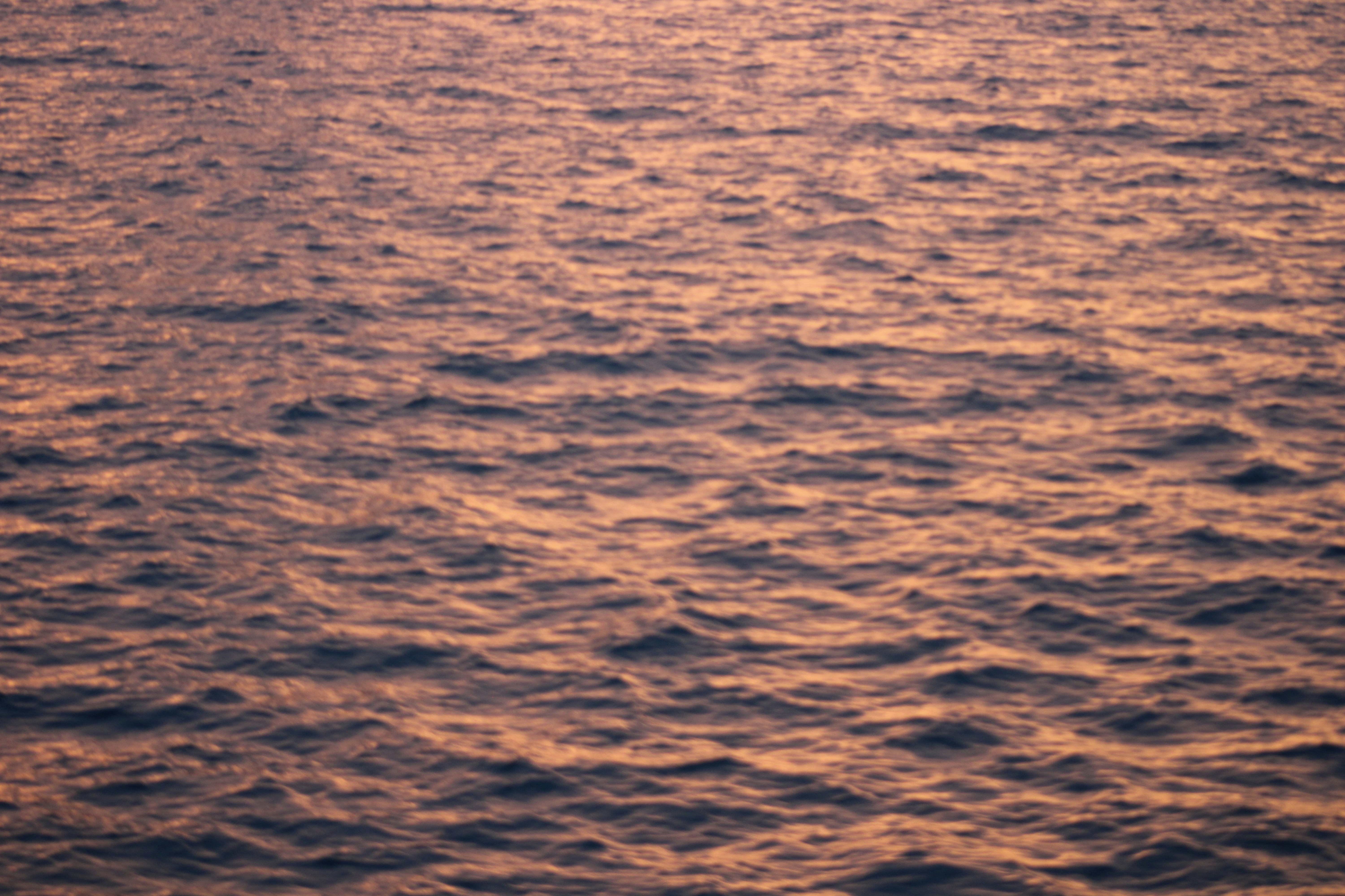 Gentle waves on the water surface at sunset