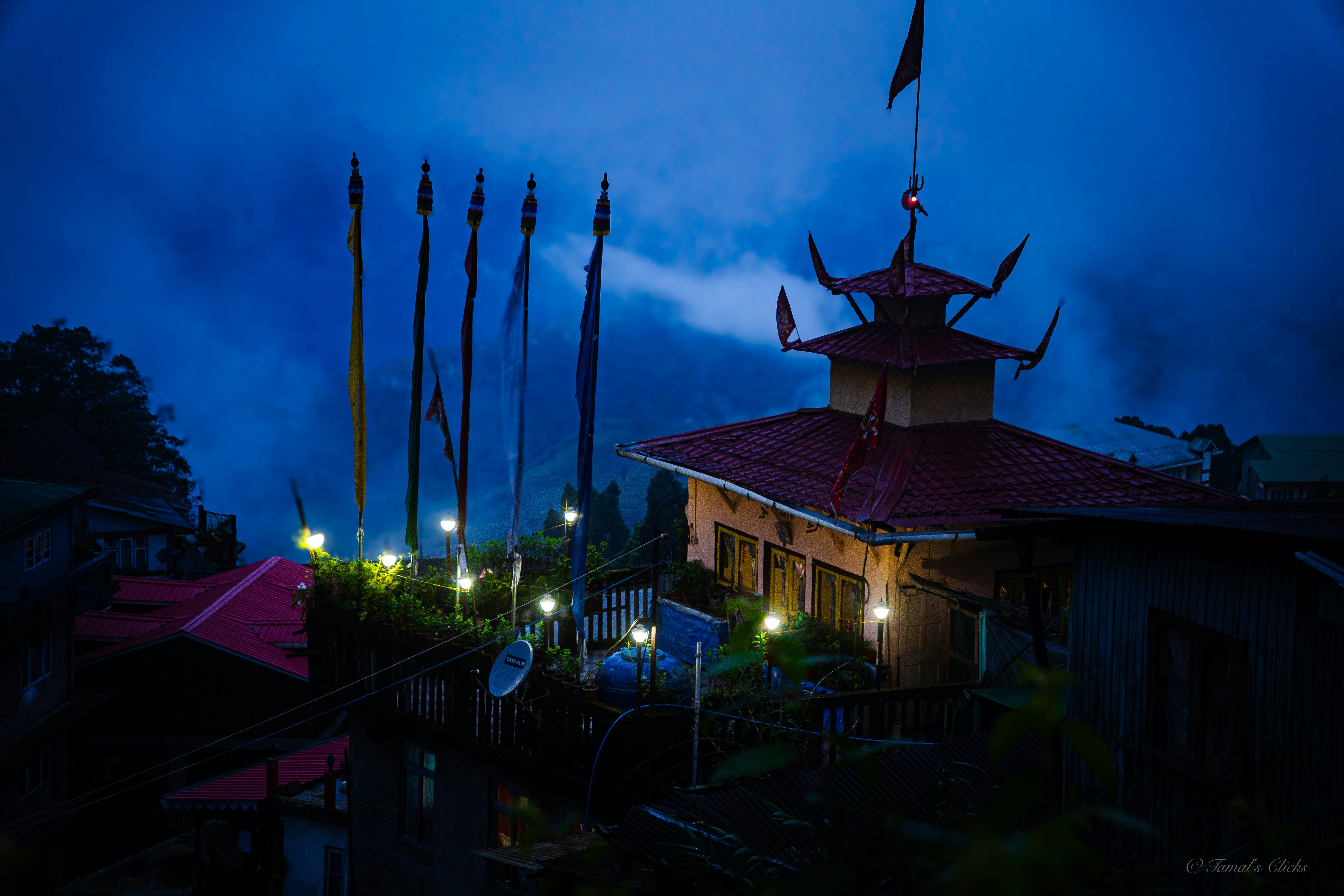 Temple illuminated at dusk with prayer flags