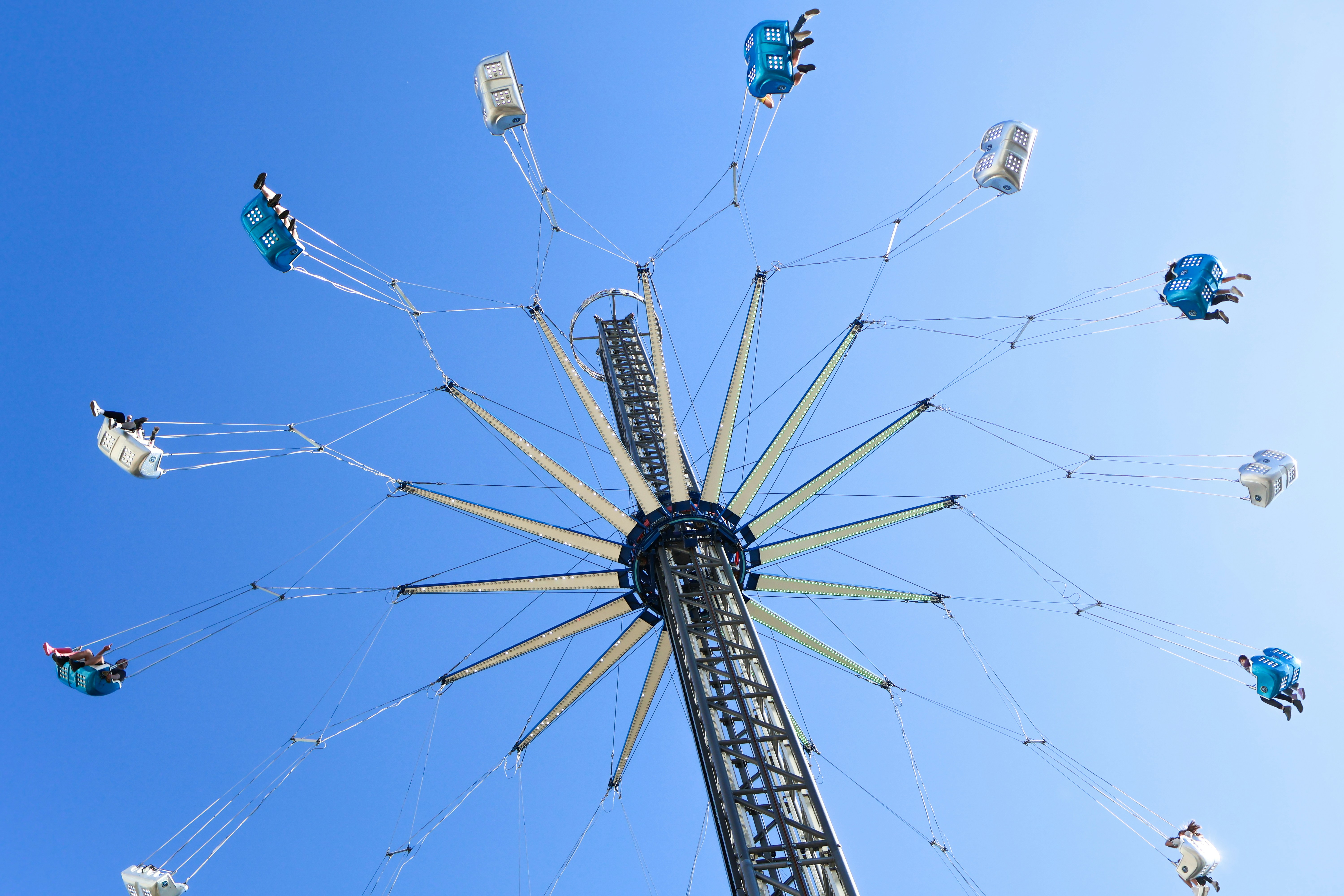 Show day | People enjoying a swing ride against a clear blue sky.