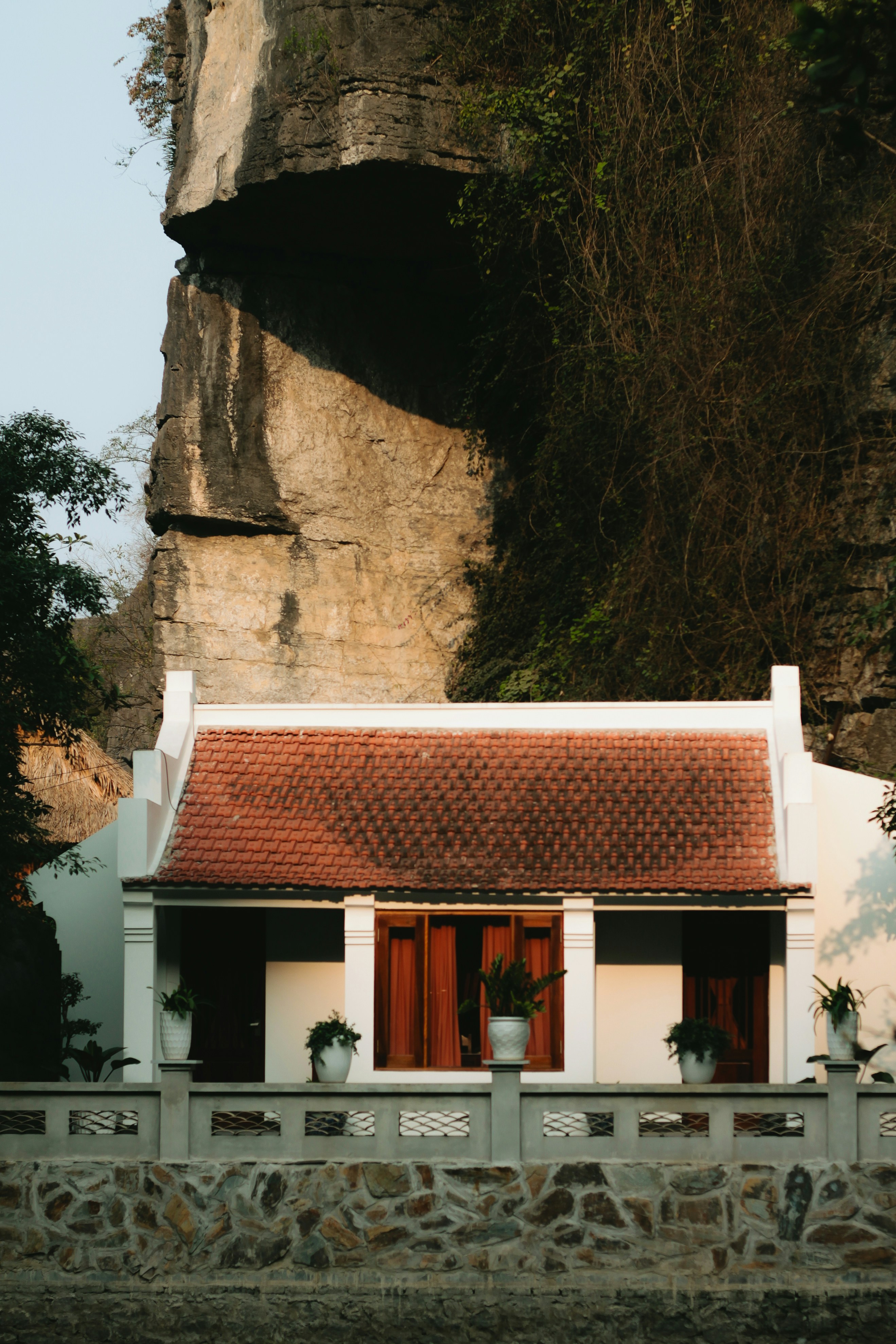 White building with red tiled roof near cliff