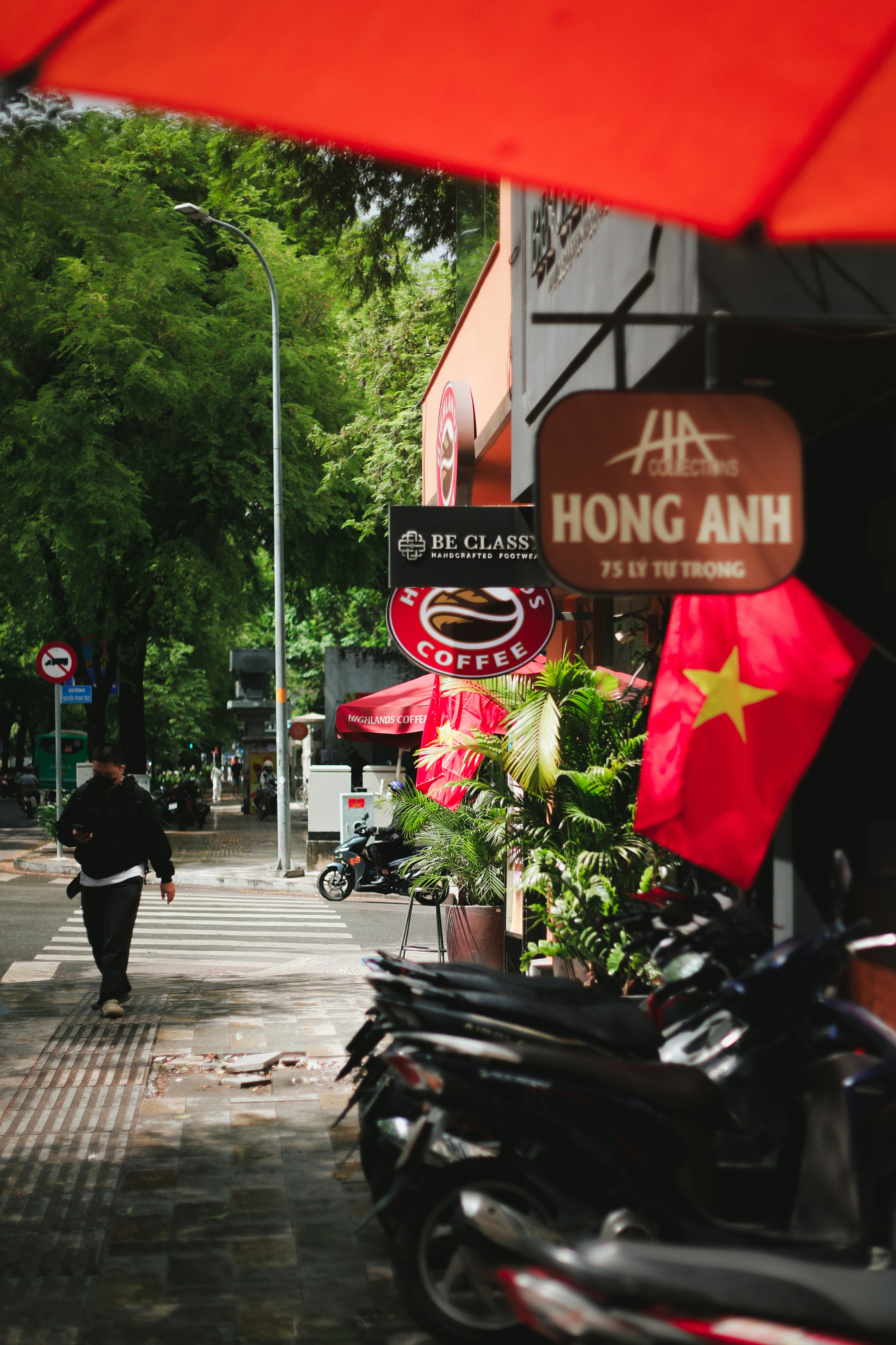 Street scene with vietnamese flag and coffee shop signs.