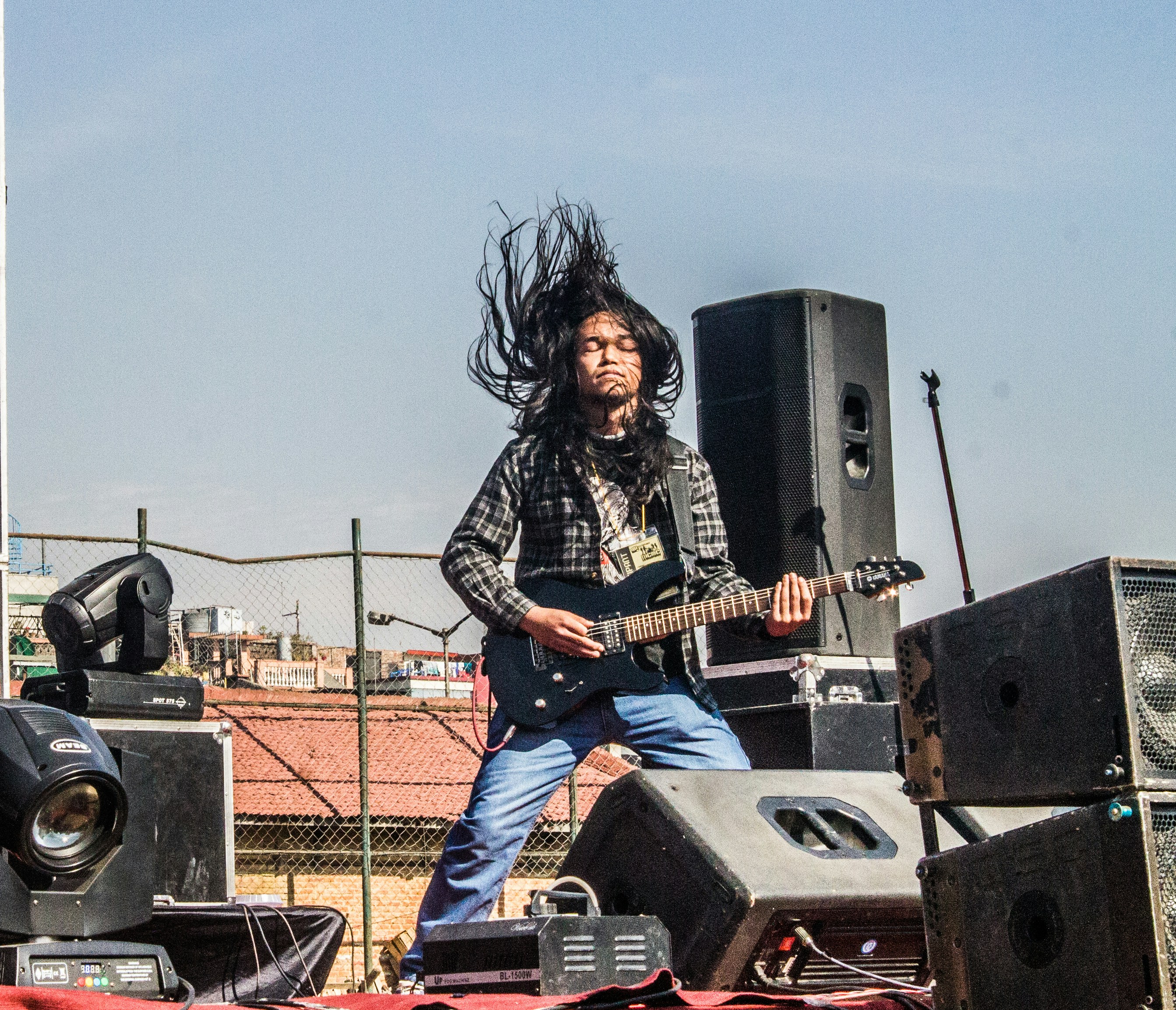Rocking the Stage: Pure Passion Under the Open Sky | A musician plays guitar energetically on stage