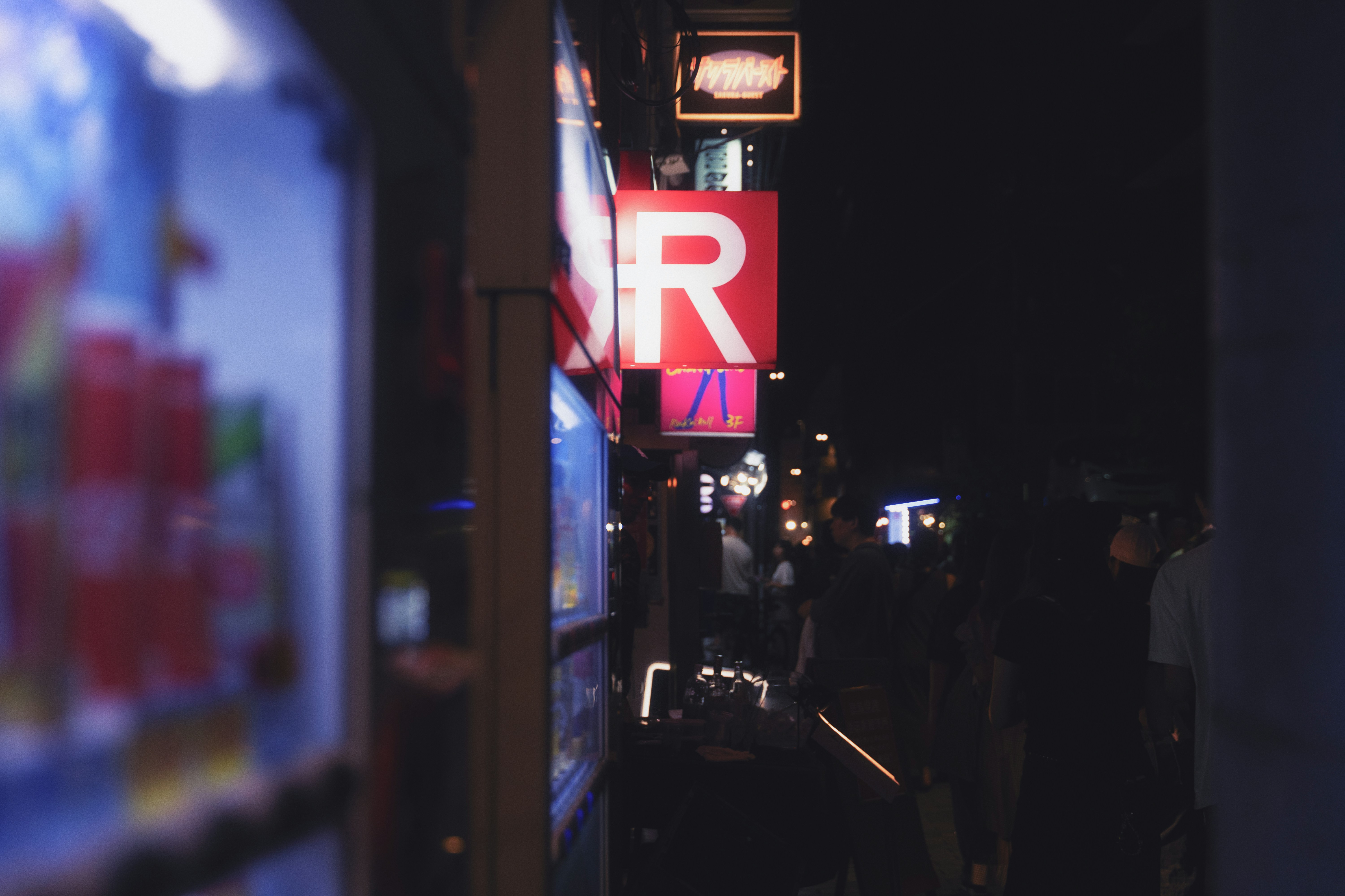 Neon signs illuminate a city street at night