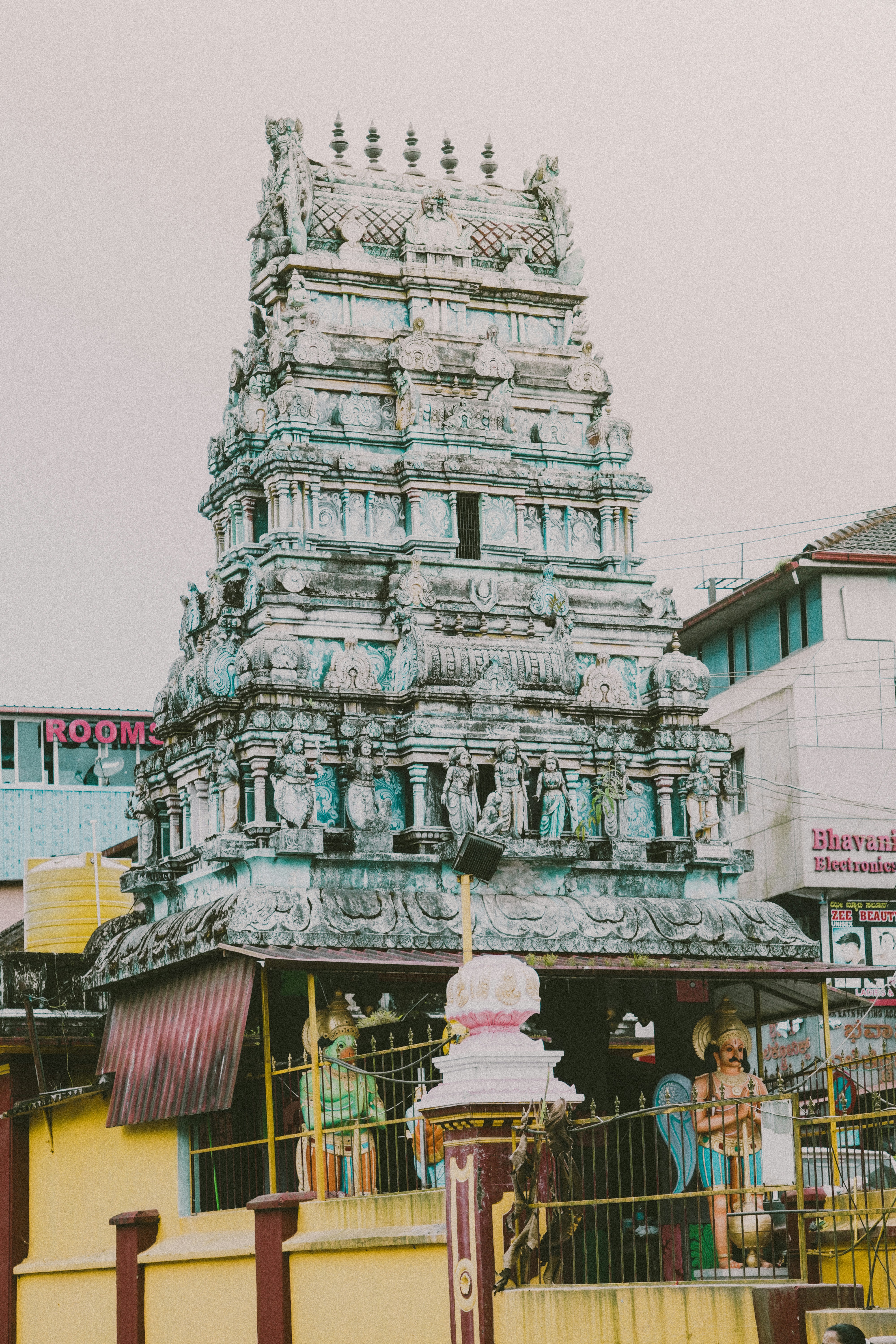 Intricately carved temple gopuram in Madikeri, showcasing traditional South Indian architecture and cultural heritage | Ornate hindu temple tower with intricate carvings and statues.
