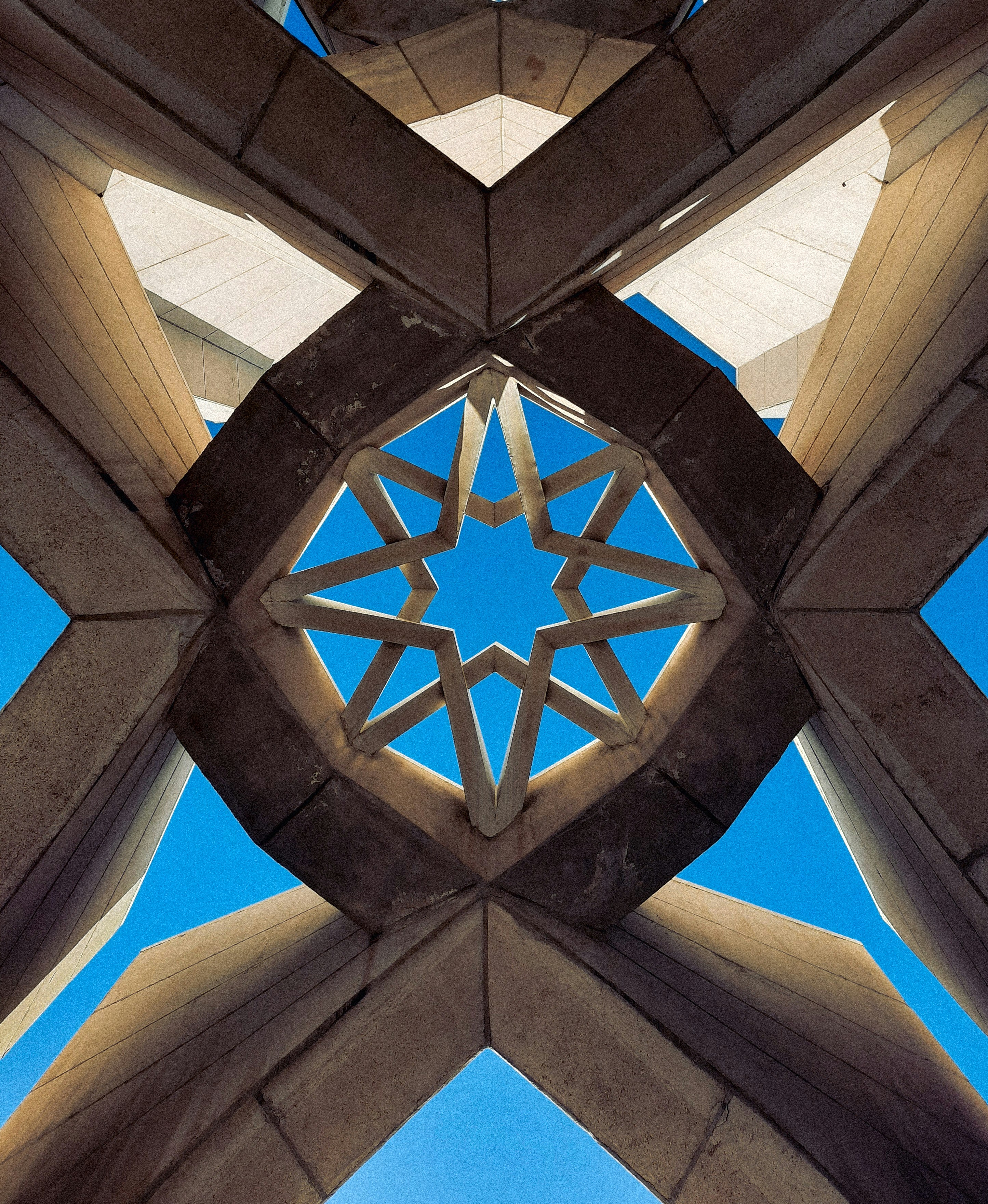 Geometric architectural structure against a clear blue sky.