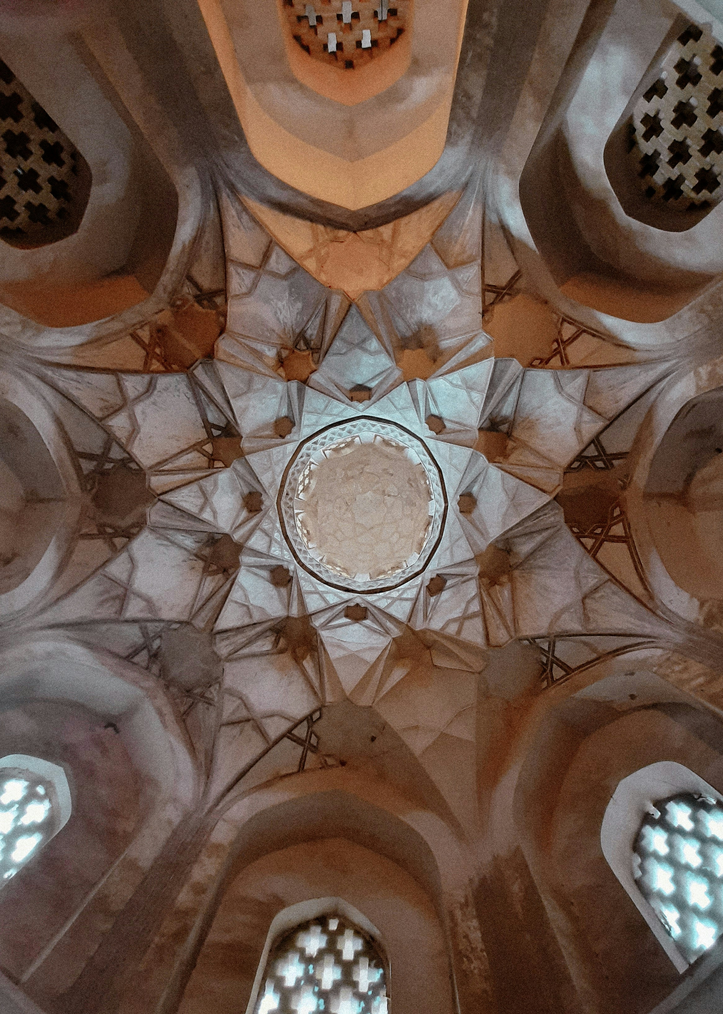 Intricate geometric patterns adorn an ornate domed ceiling.