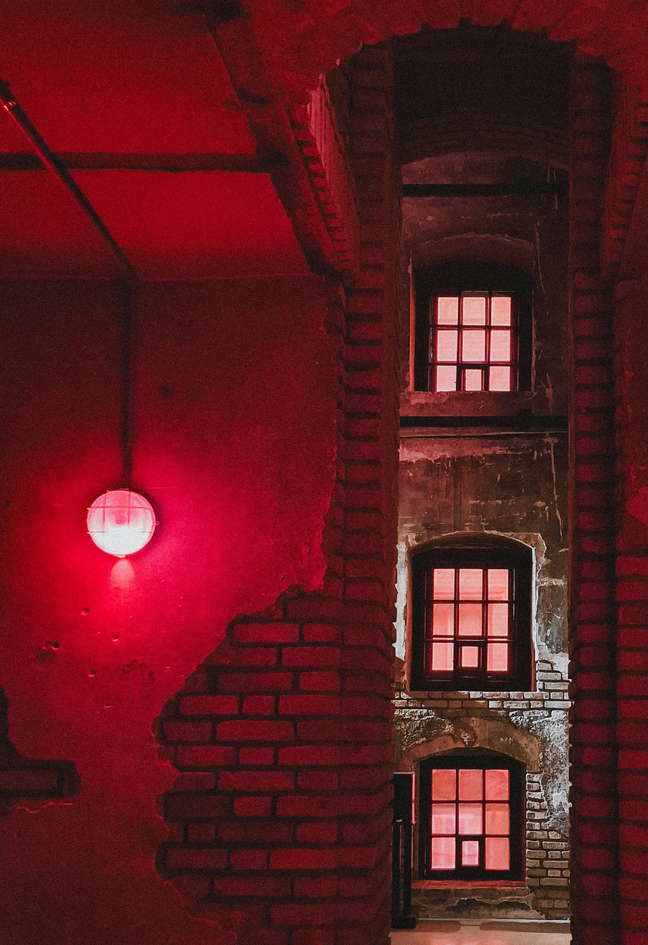 Red-walled stairwell: a doorway into dim crimson light